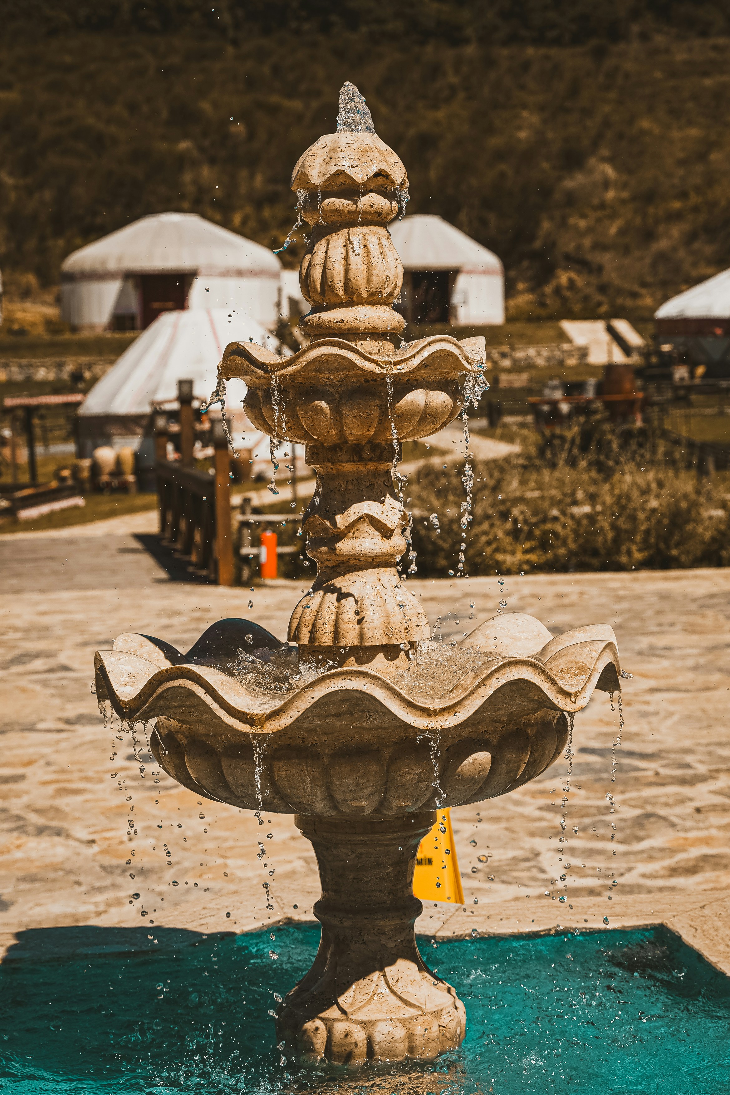 Whispering Tiers at a Nomad Camp: A Stone Fountain in Warm Light