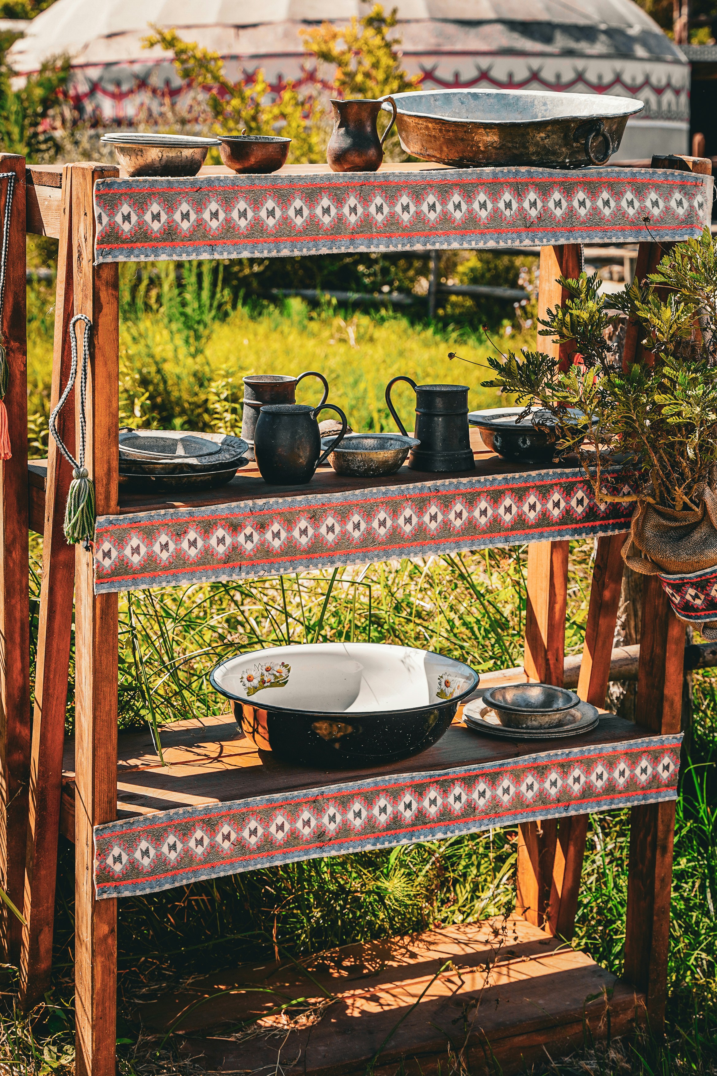 Sunlit Rustic Still-Life: Earthenware and Linen on a Wooden Outdoor Shelf