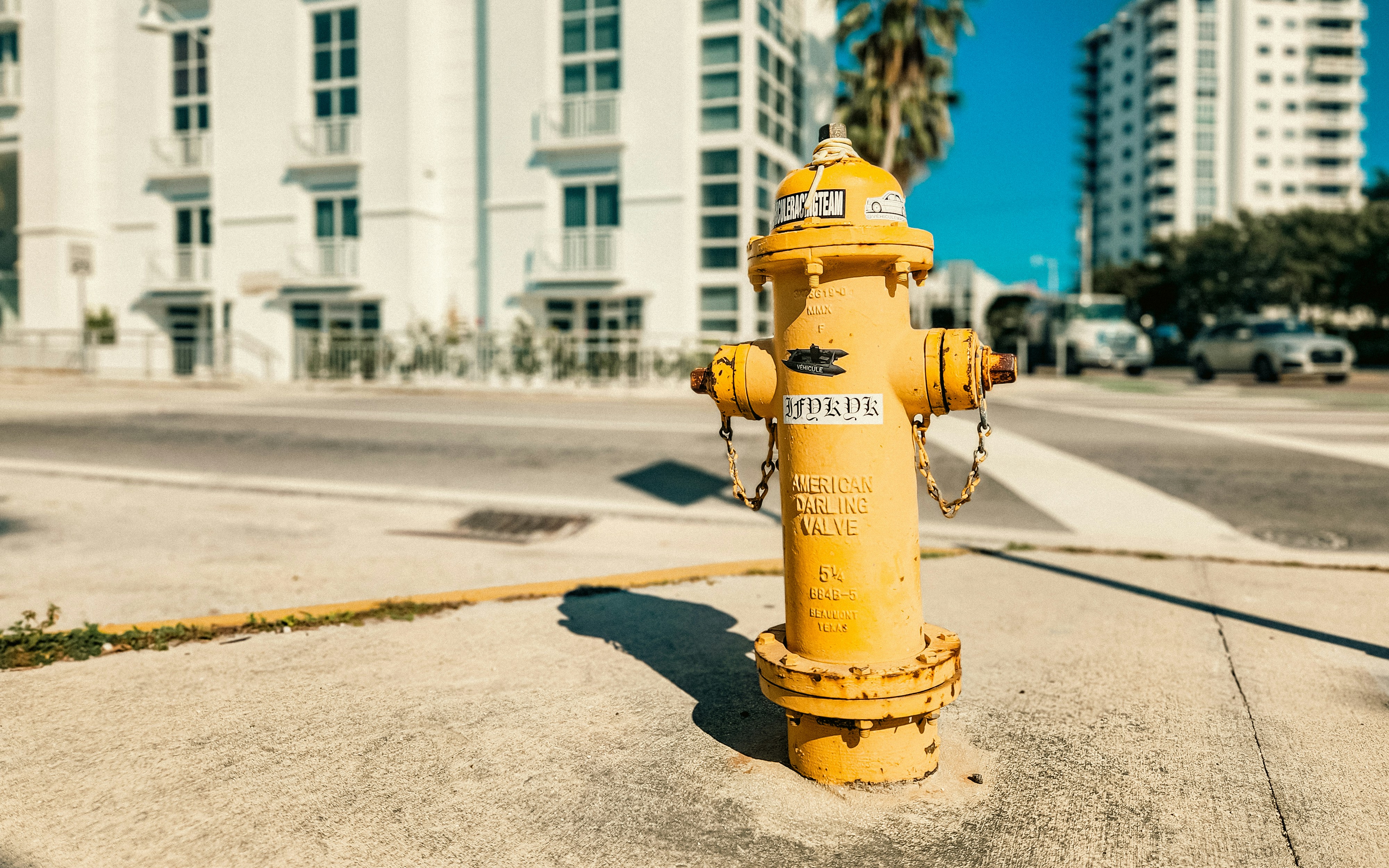 A yellow fire hydrant stands on the sidewalk, a vital part of the city's emergency water supply system. Painted yellow to indicate a public water source, it provides firefighters quick access in case of a fire. Typically made of cast iron, hydrants are connected to underground pipes and can deliver thousands of gallons per minute. Found on streets worldwide, their colors and markings often indicate water pressure levels. Regularly maintained by municipal authorities, they are essential for urban fire safety and preparedness.