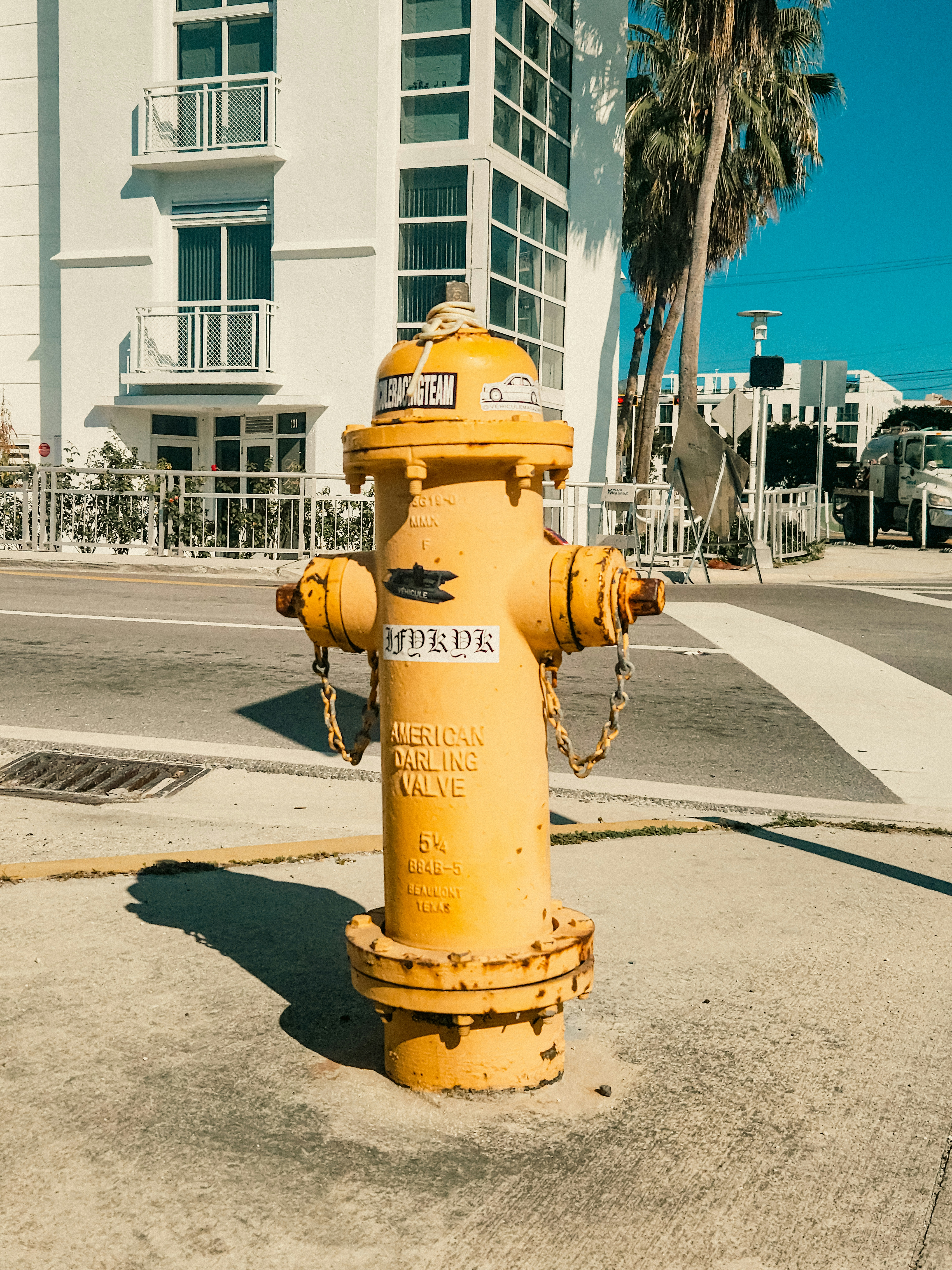 A yellow fire hydrant stands on the sidewalk, a vital part of the city's emergency water supply system. Painted yellow to indicate a public water source, it provides firefighters quick access in case of a fire. Typically made of cast iron, hydrants are connected to underground pipes and can deliver thousands of gallons per minute. Found on streets worldwide, their colors and markings often indicate water pressure levels. Regularly maintained by municipal authorities, they are essential for urban fire safety and preparedness.