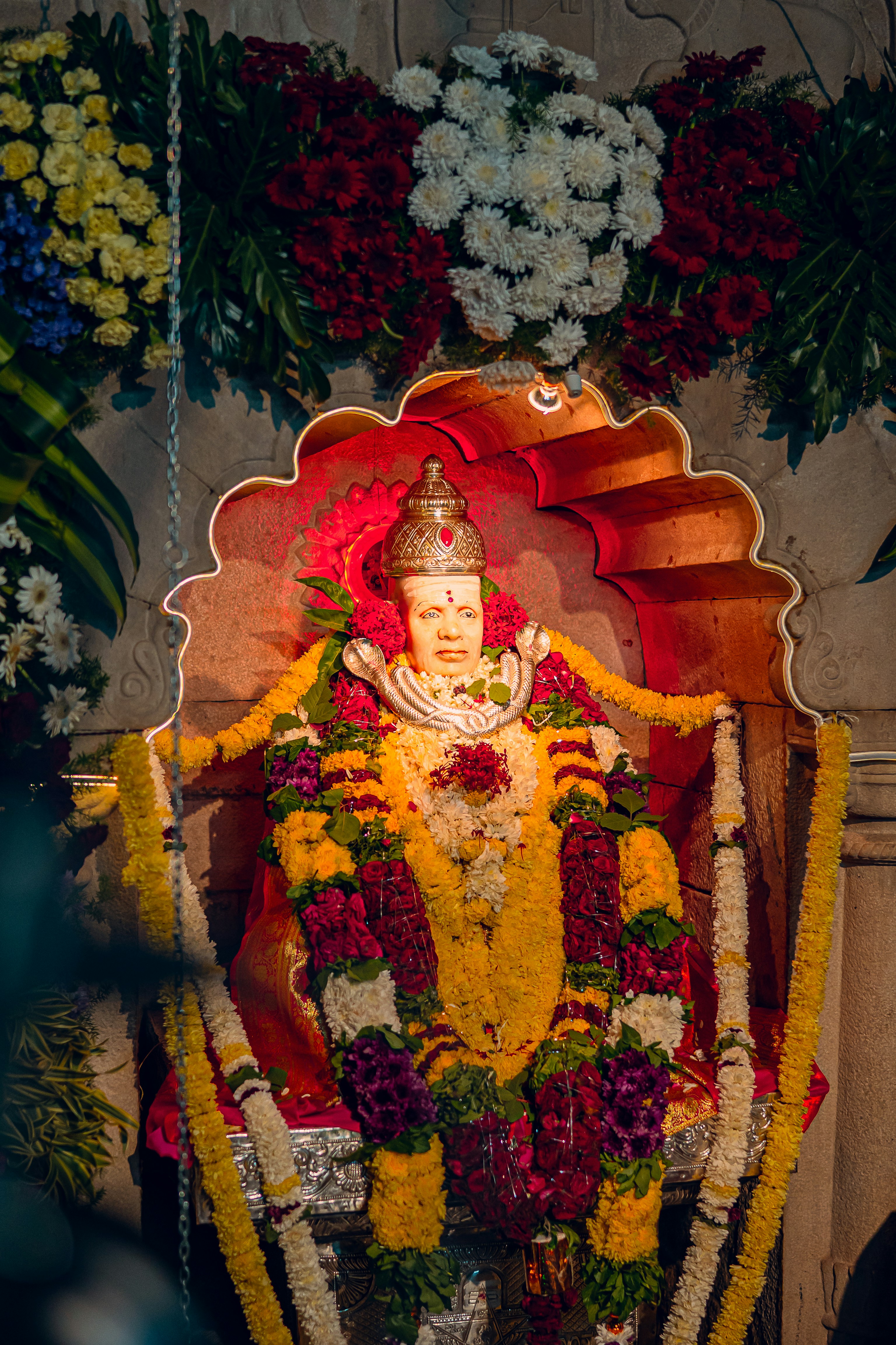 Una estatua de una persona con flores a su alrededor foto – Imagen de ...