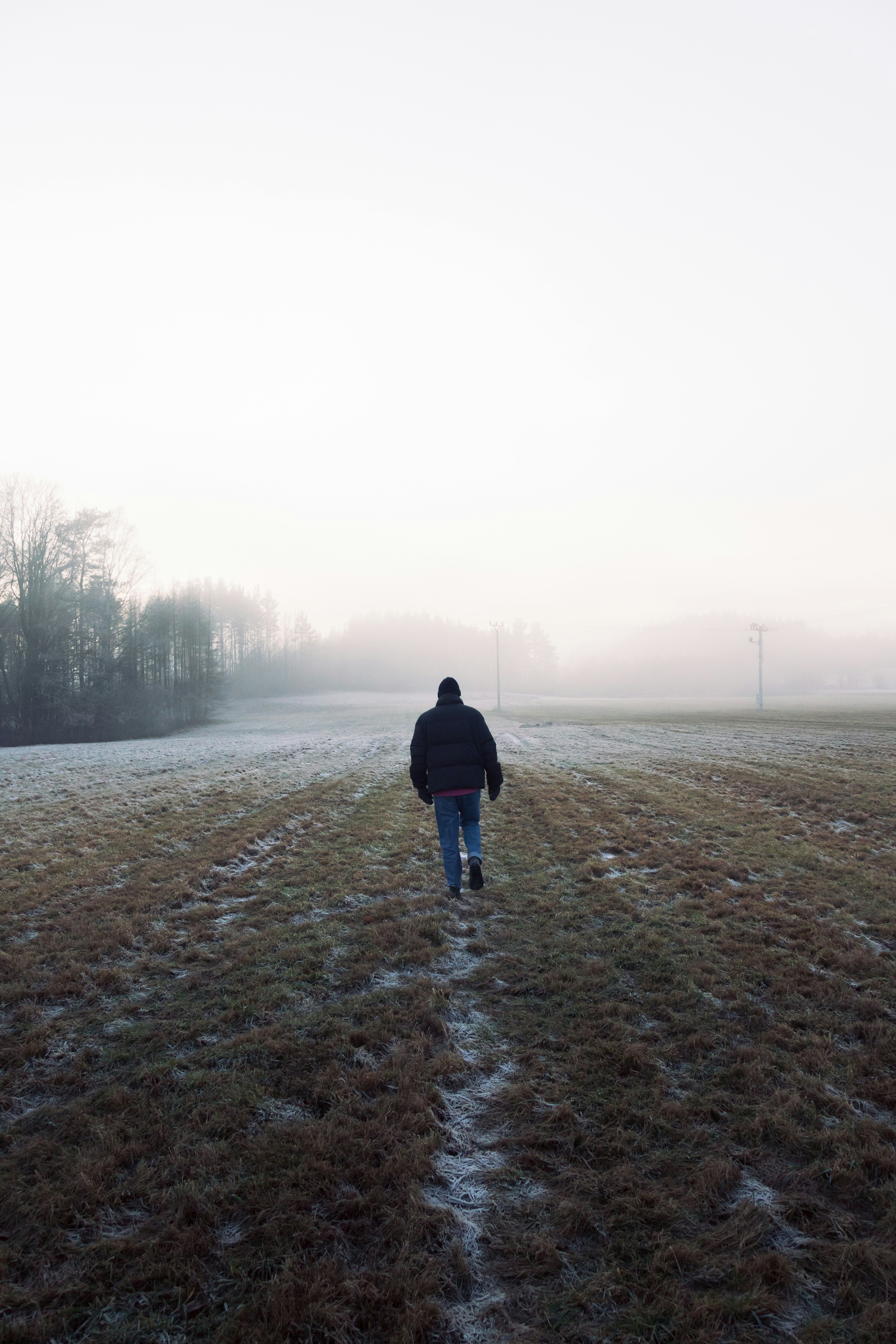 A man walking across a field in the middle of winter photo – Free Czech ...