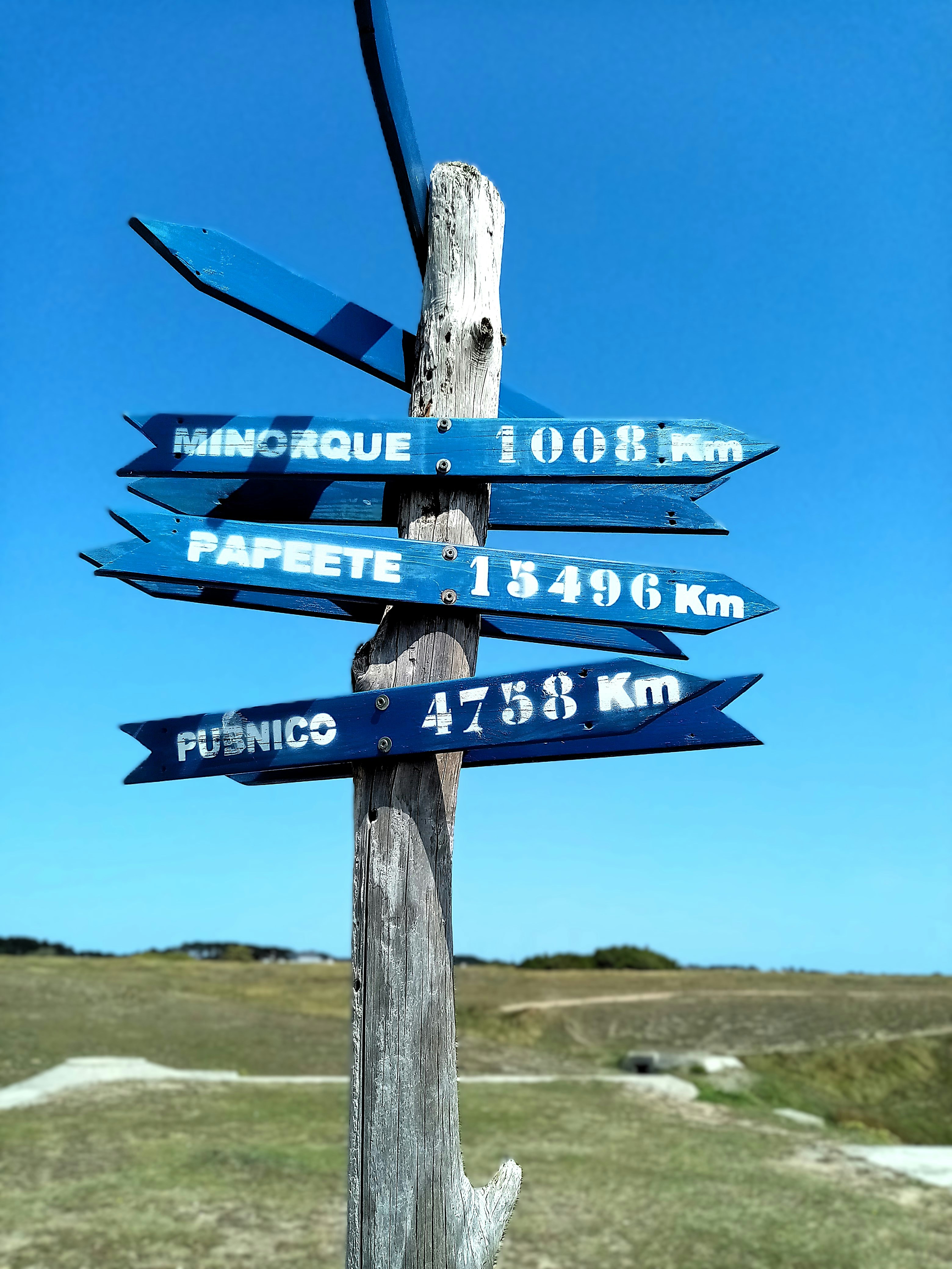 A wooden pole with a bunch of signs on it photo – Free Belle-île-en-mer ...