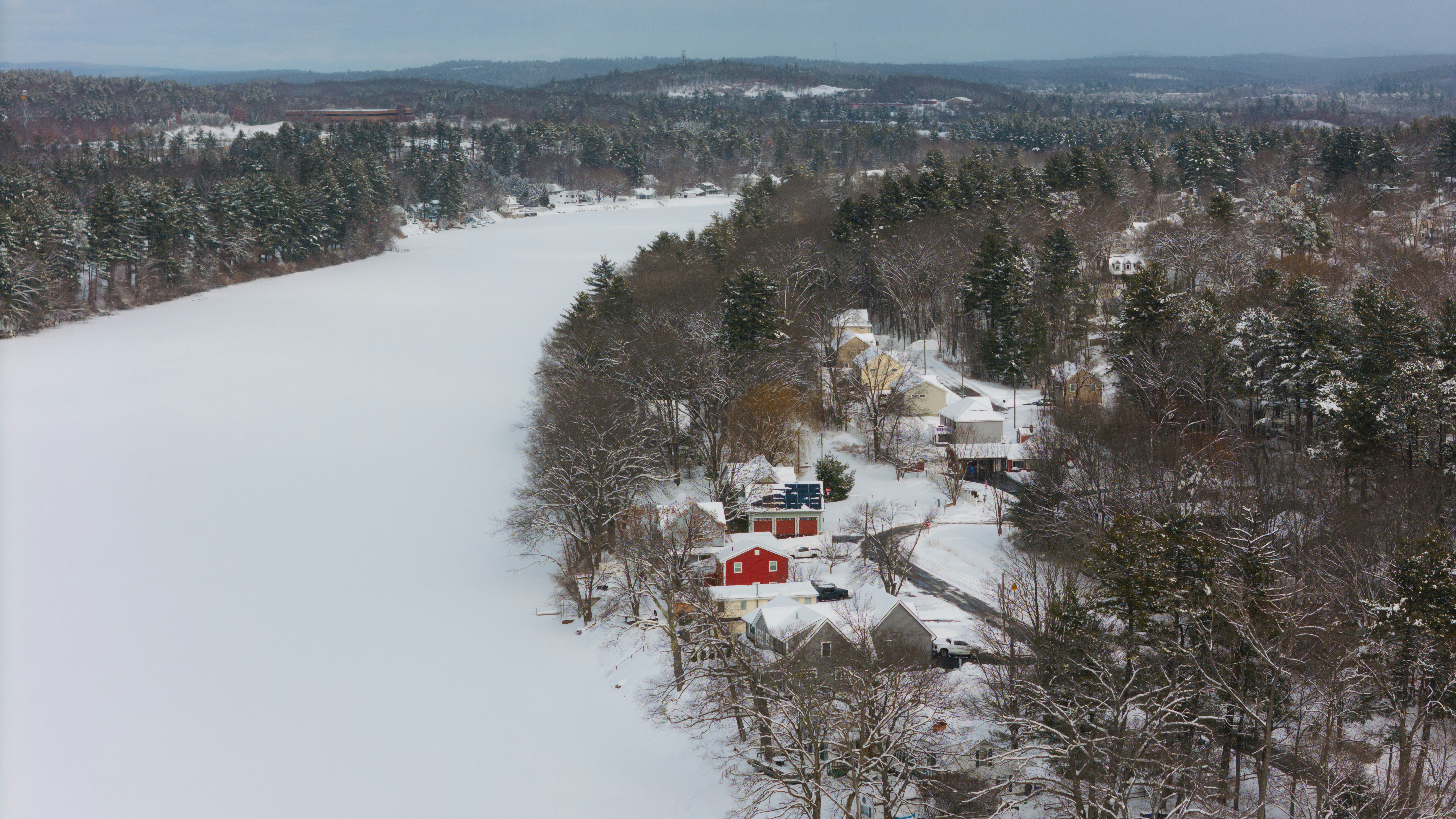 An aerial view of a snow covered area with a river running through it ...