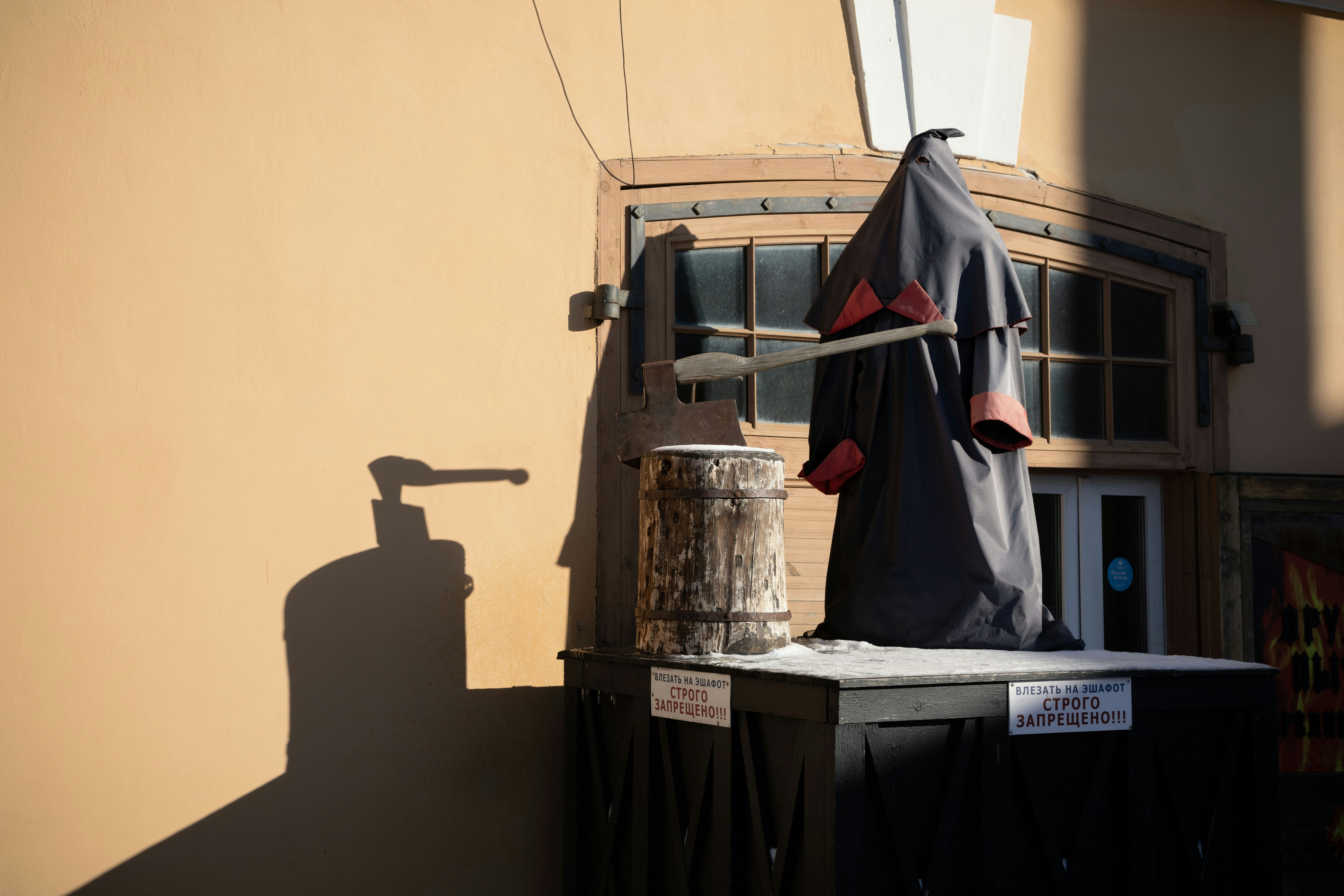 Draped Figure on a Sunlit Platform: A Silent Courtyard Portrait
