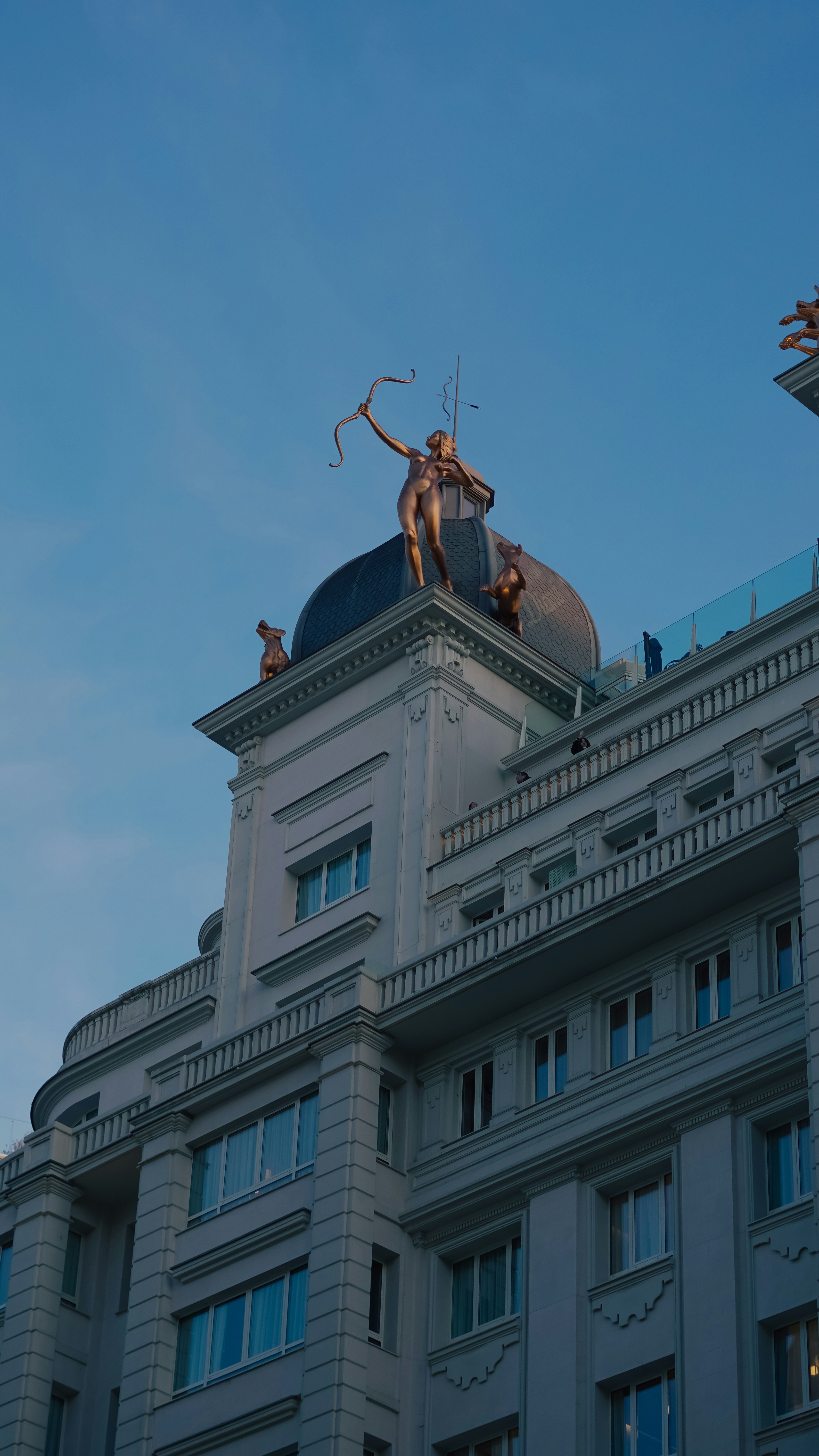 Statue on a Rooftop: A Skyward Gaze Above the City