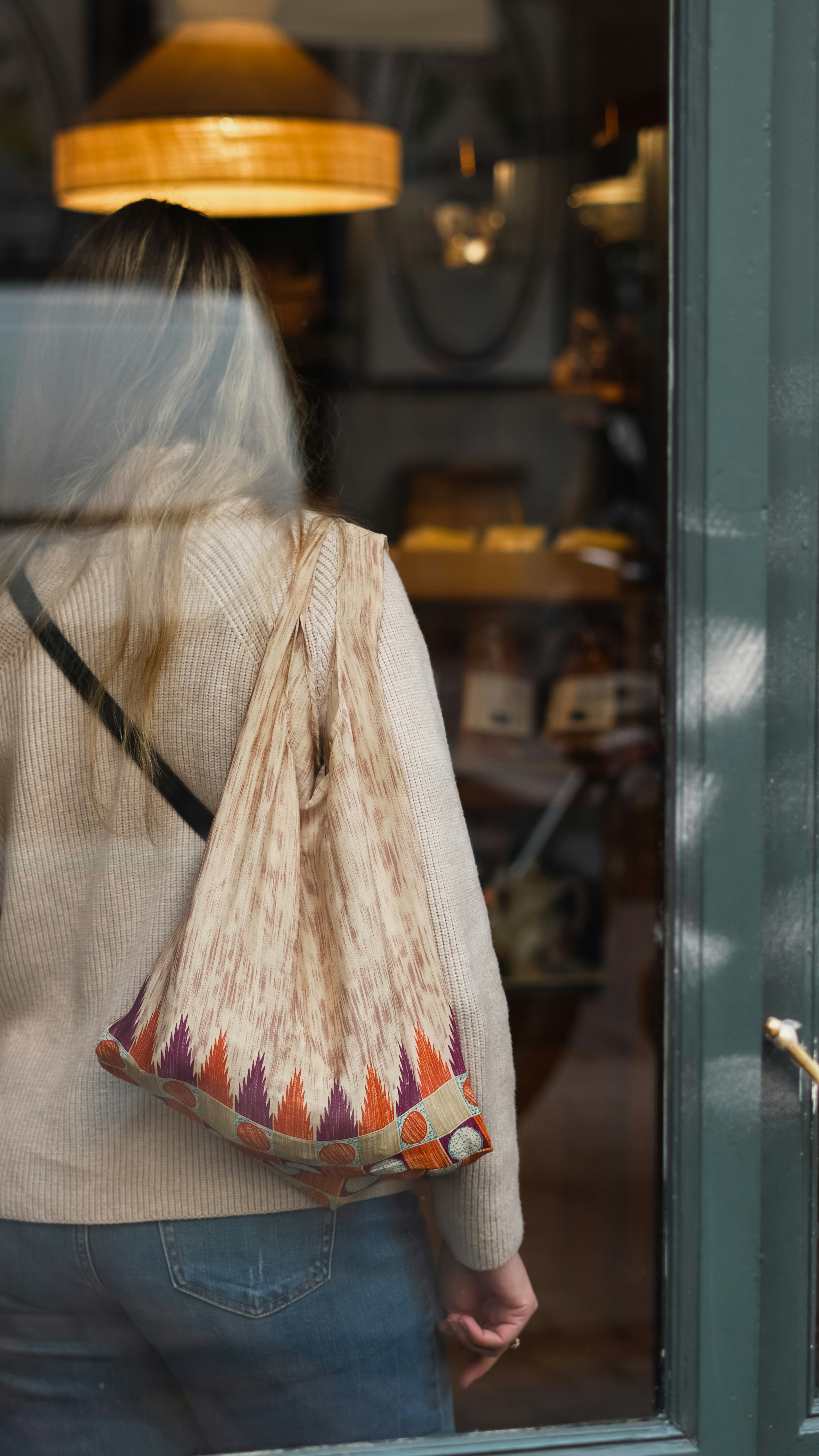 A woman walking past a store front window photo – Free Madrid Image on ...