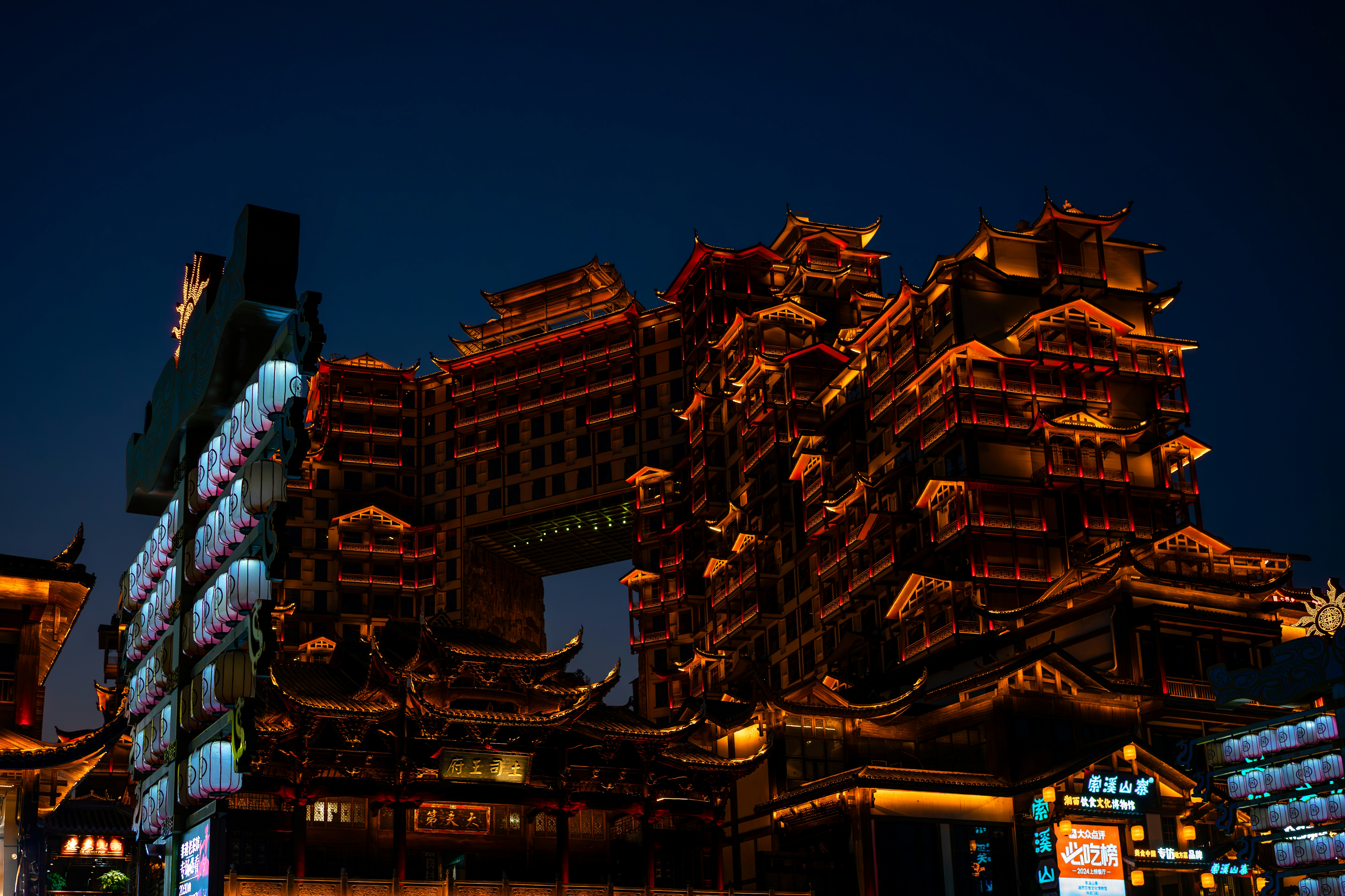 Traditional-style building glowing with warm lights under a deep blue evening sky.