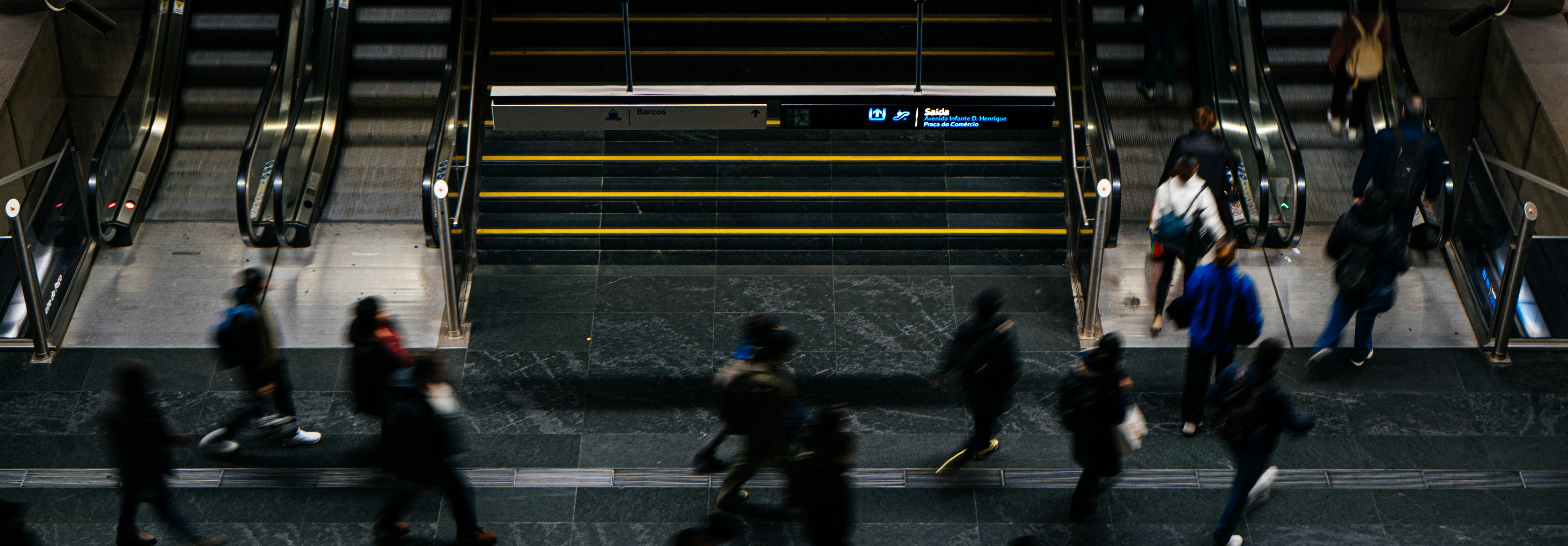 Motion in the Atrium: Blurred Crowds Beneath Stainless Escalators