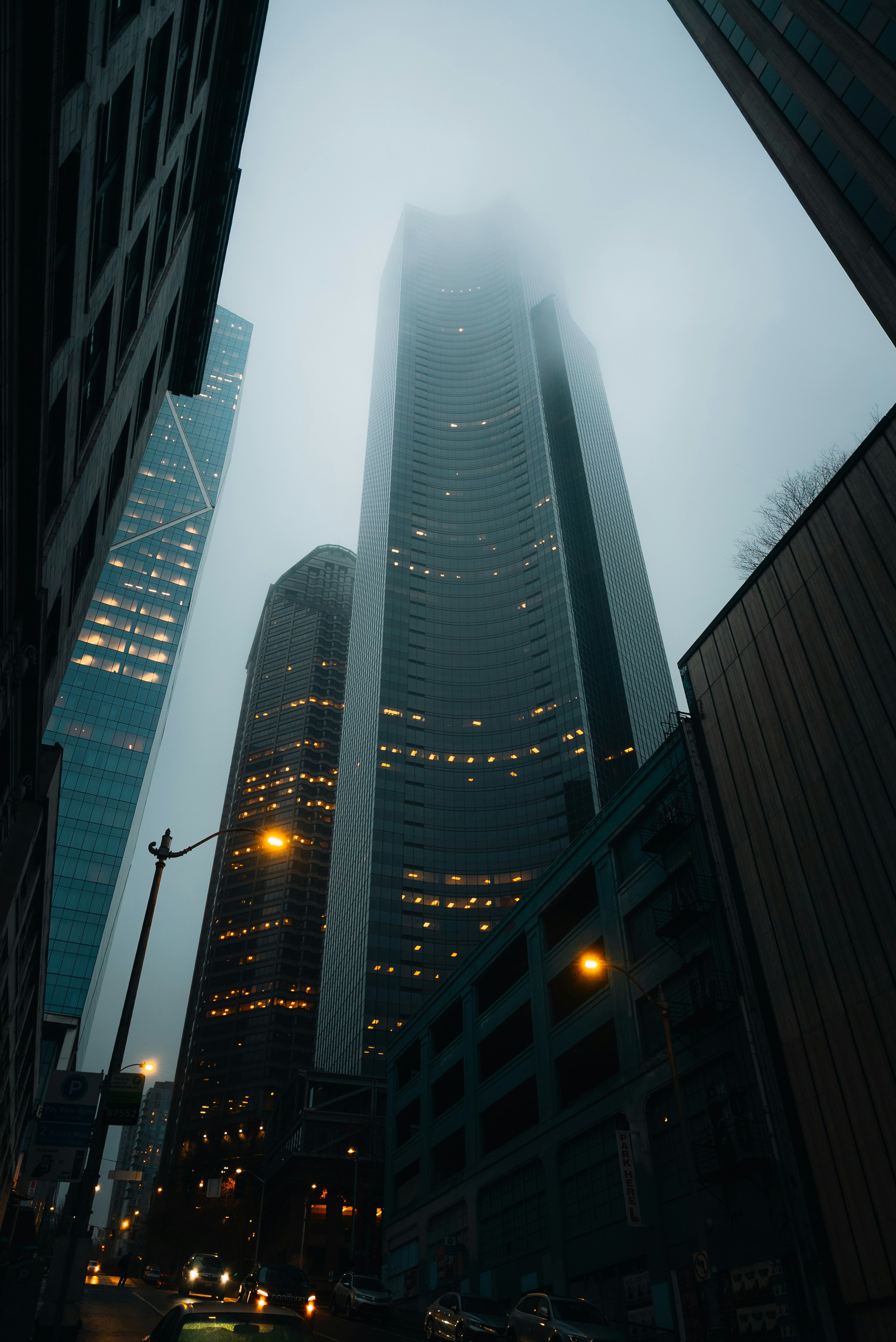 A very tall building towering over a city at night photo – Free Rain ...