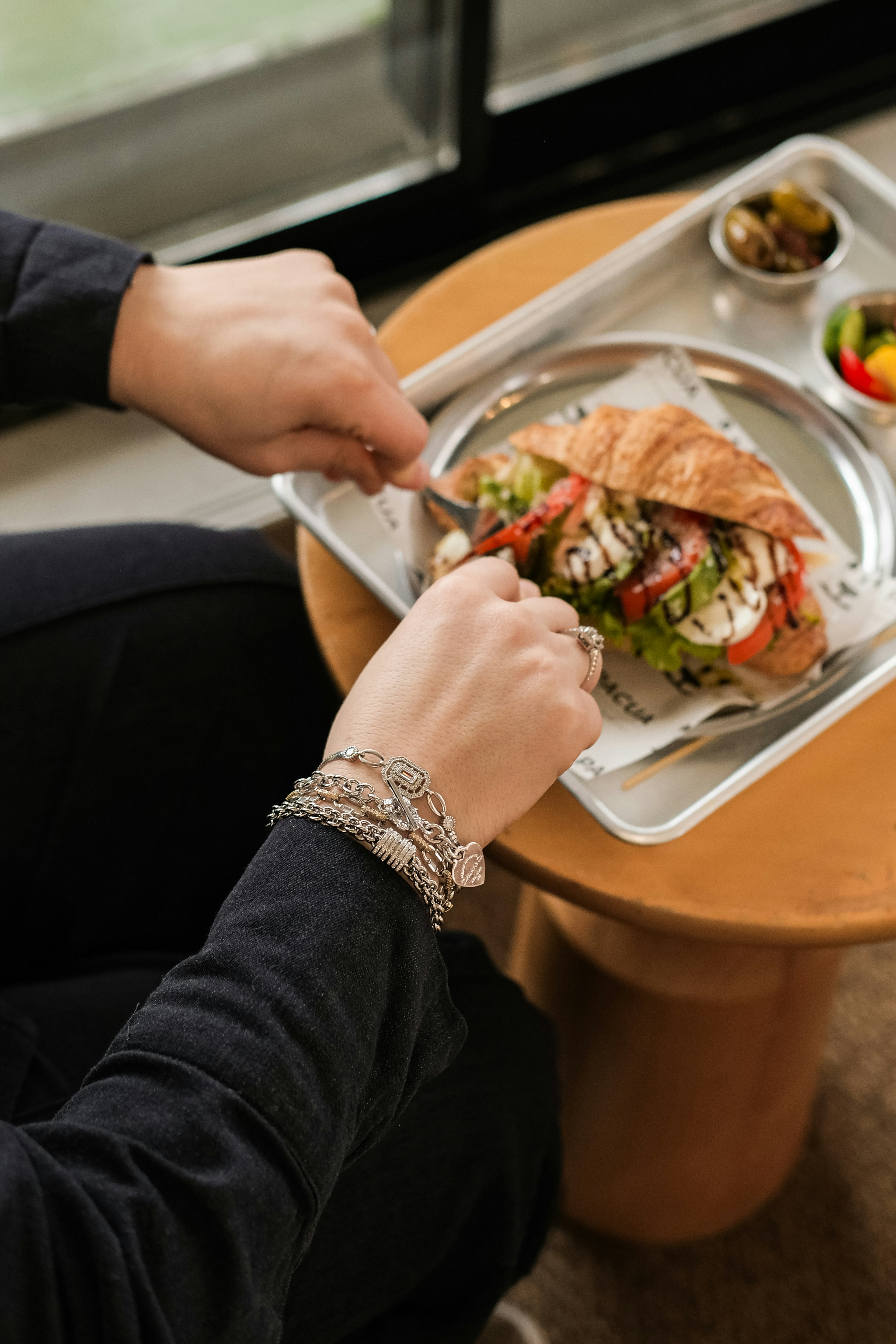 Hands at the Tray: A Forkful of Breakfast Burger by the Window