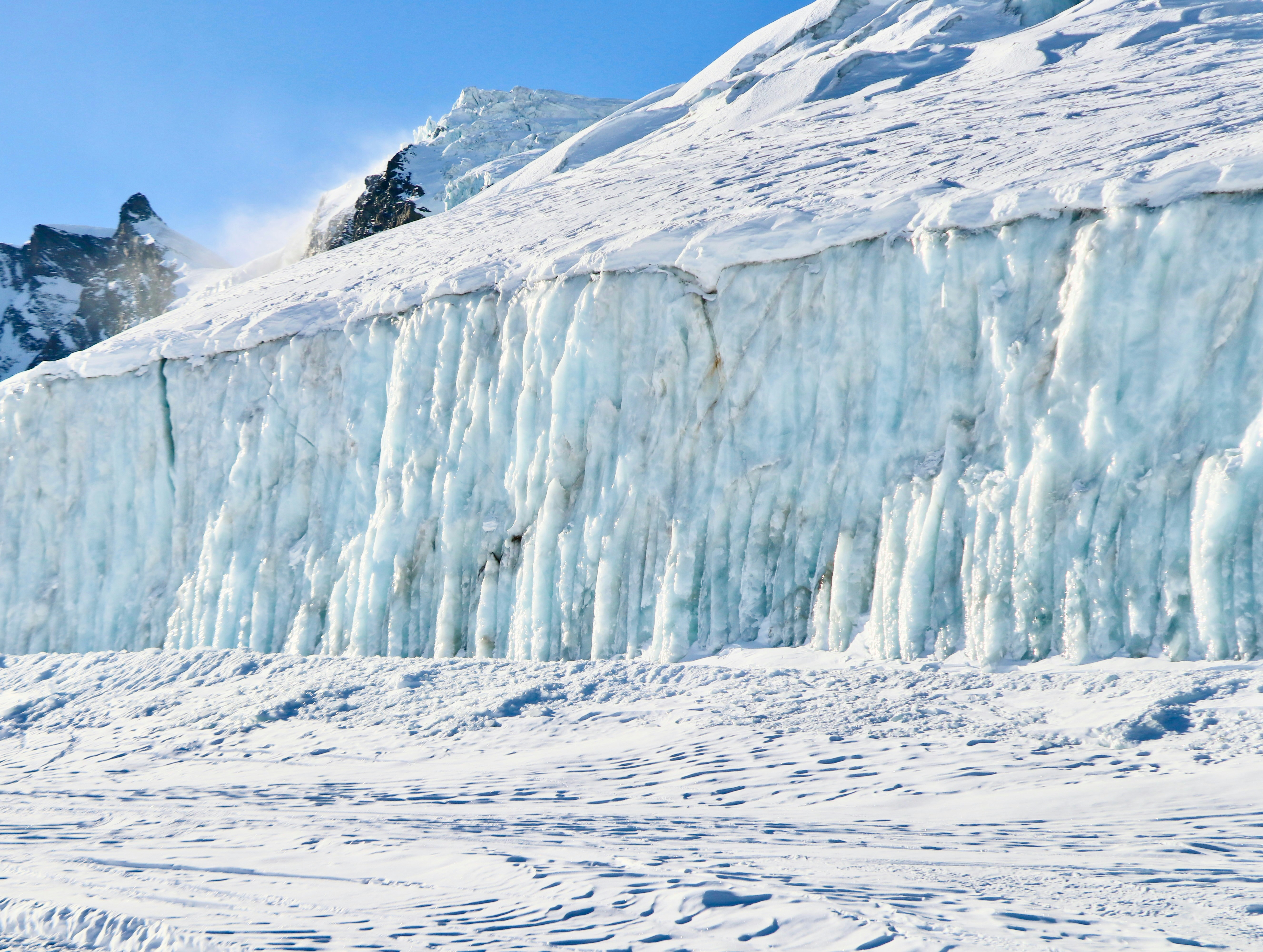 Azure Icefall: Vertical Glacier Facade Under a Clear Blue Sky