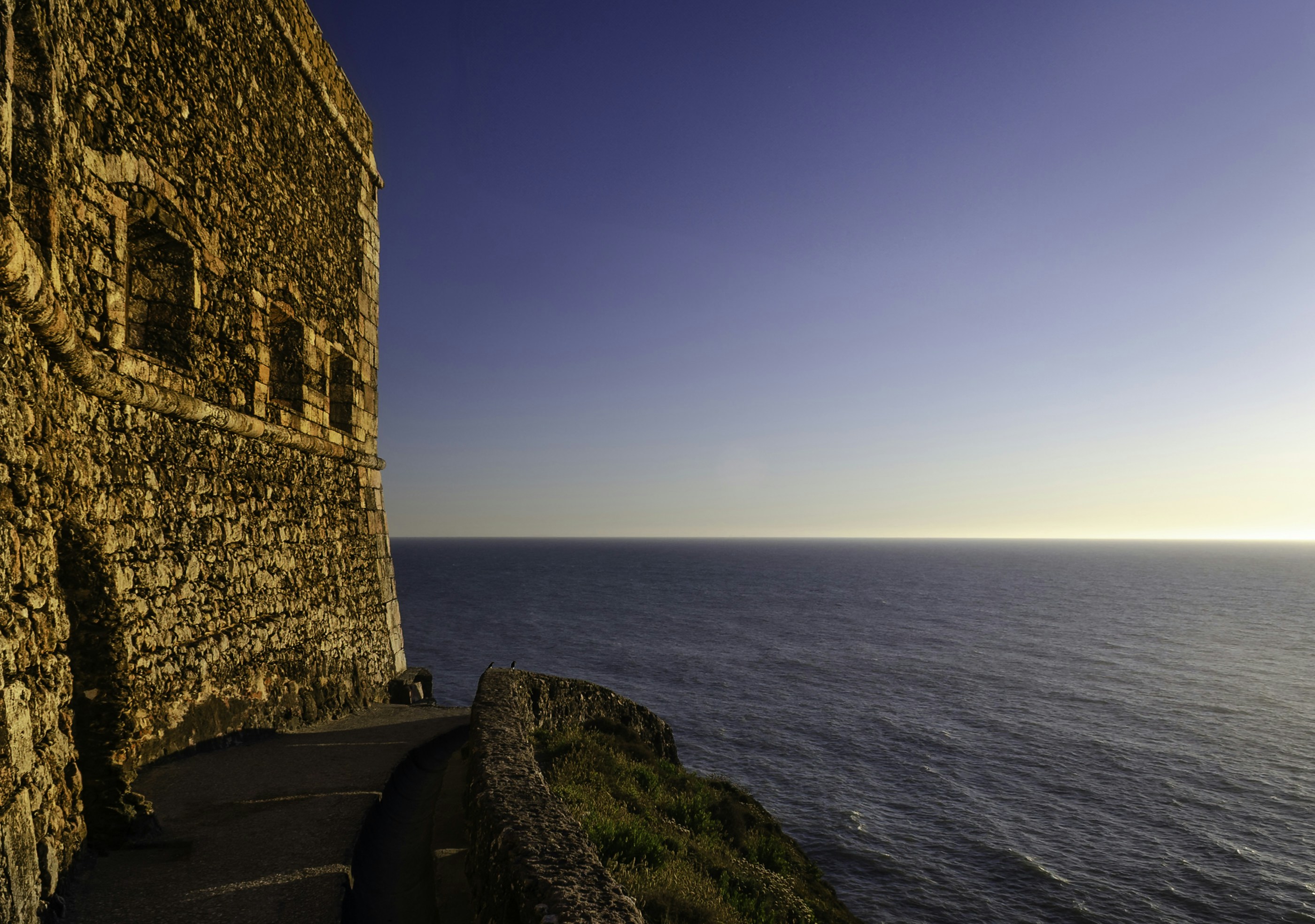 Historic Lighthouse Wall Embracing the Atlantic Horizon