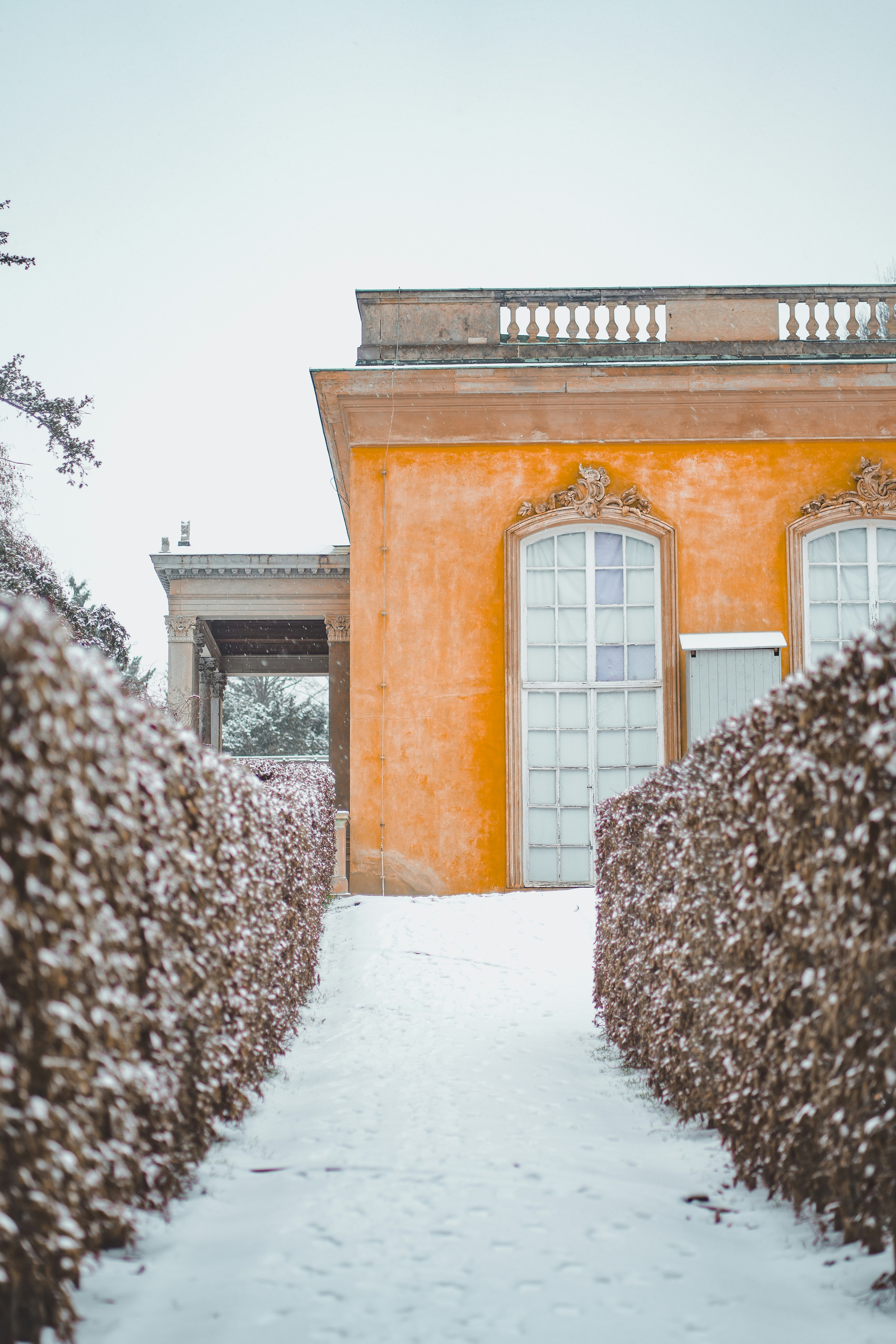 Un bâtiment orange avec deux portes et un chemin enneigé photo – Image ...