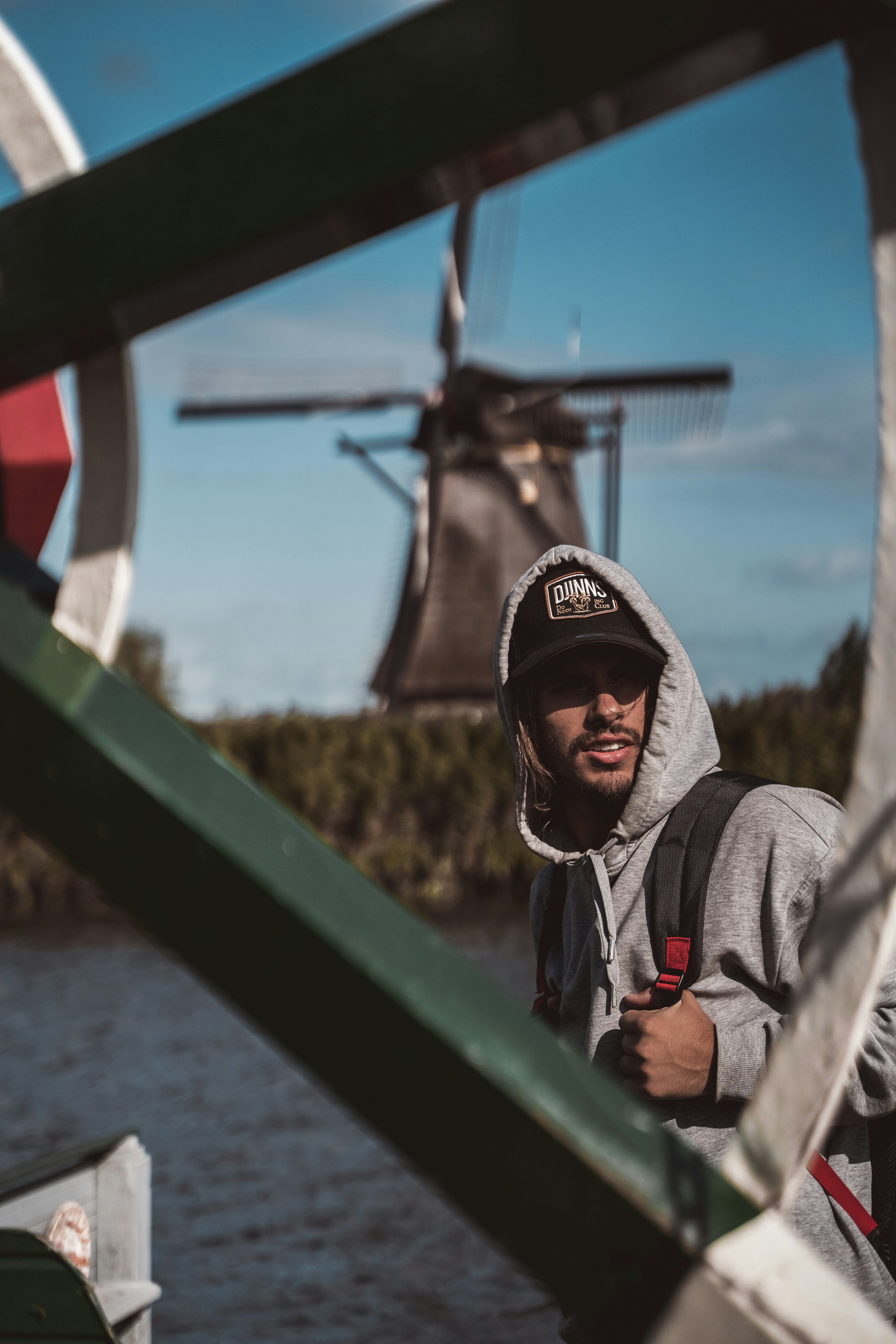 Hooded Traveler Framed by a Dutch Windmill