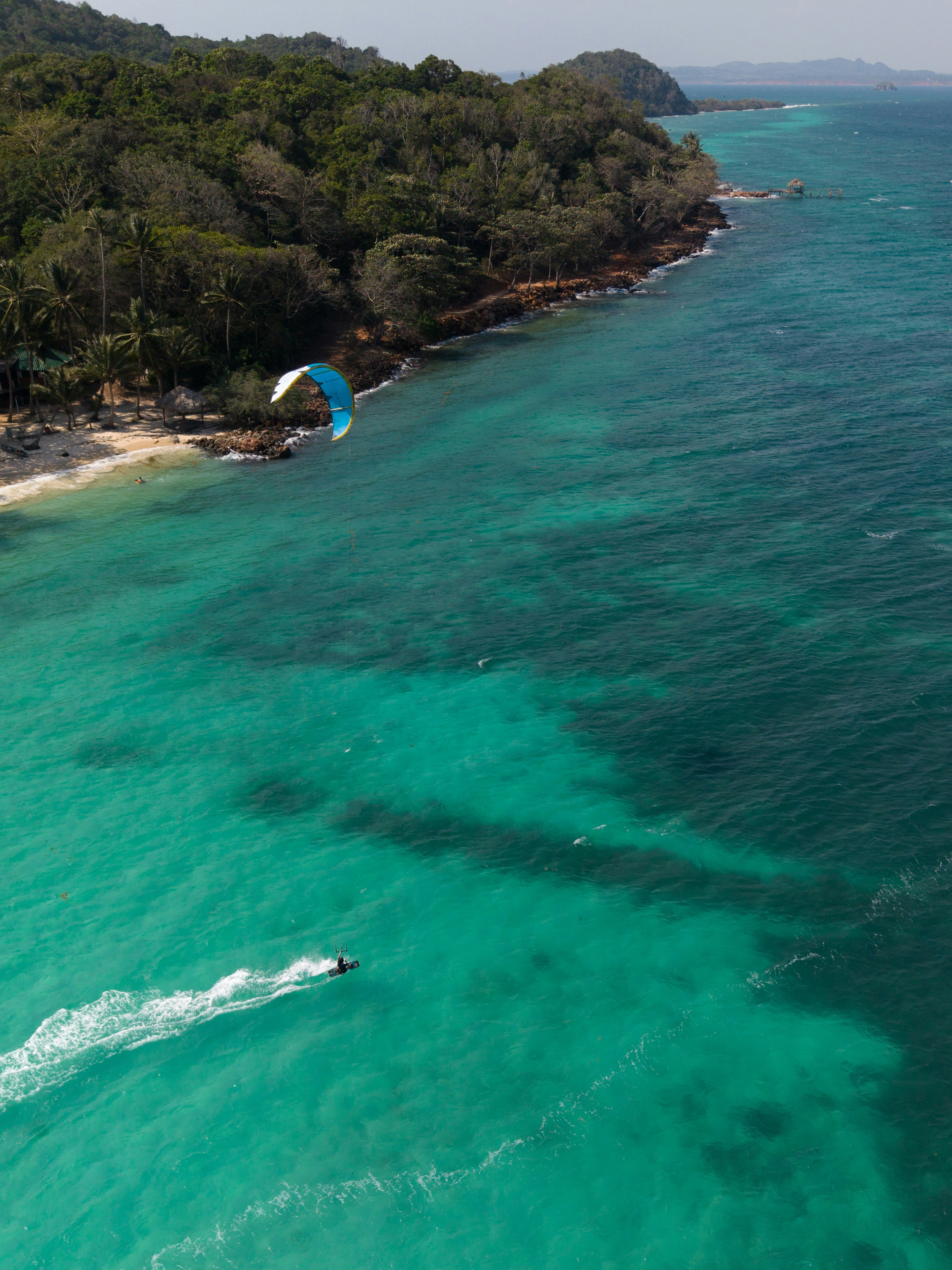 Une vue aérienne d’une personne en parachute ascensionnel dans l’océan ...