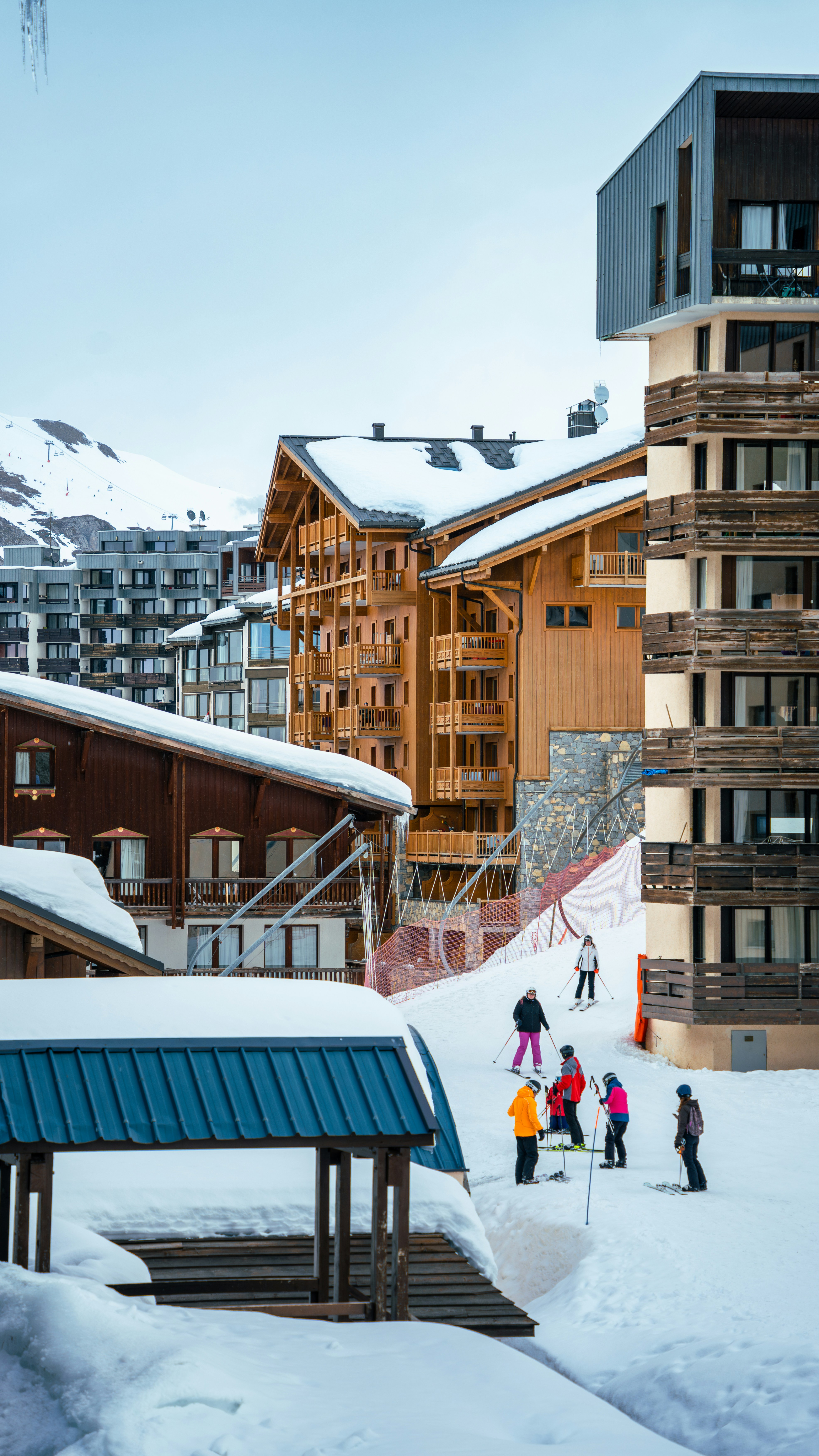 Skiers gather at the base of a snowy slope, surrounded by charming alpine architecture. The scene captures the essence of winter sports in a picturesque mountain setting.