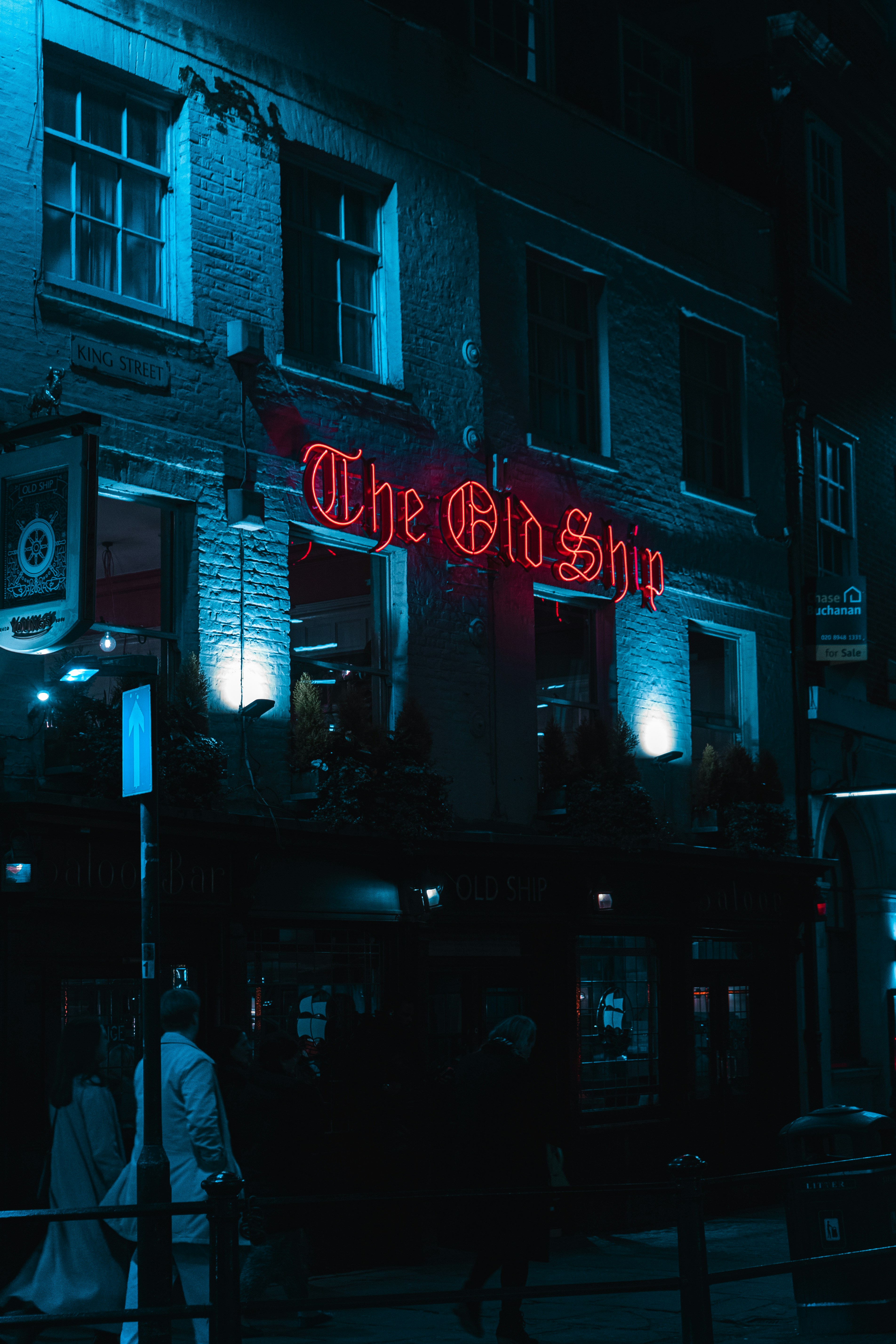 Neon Script on a Blue Brick Facade: The Old Ship at Night