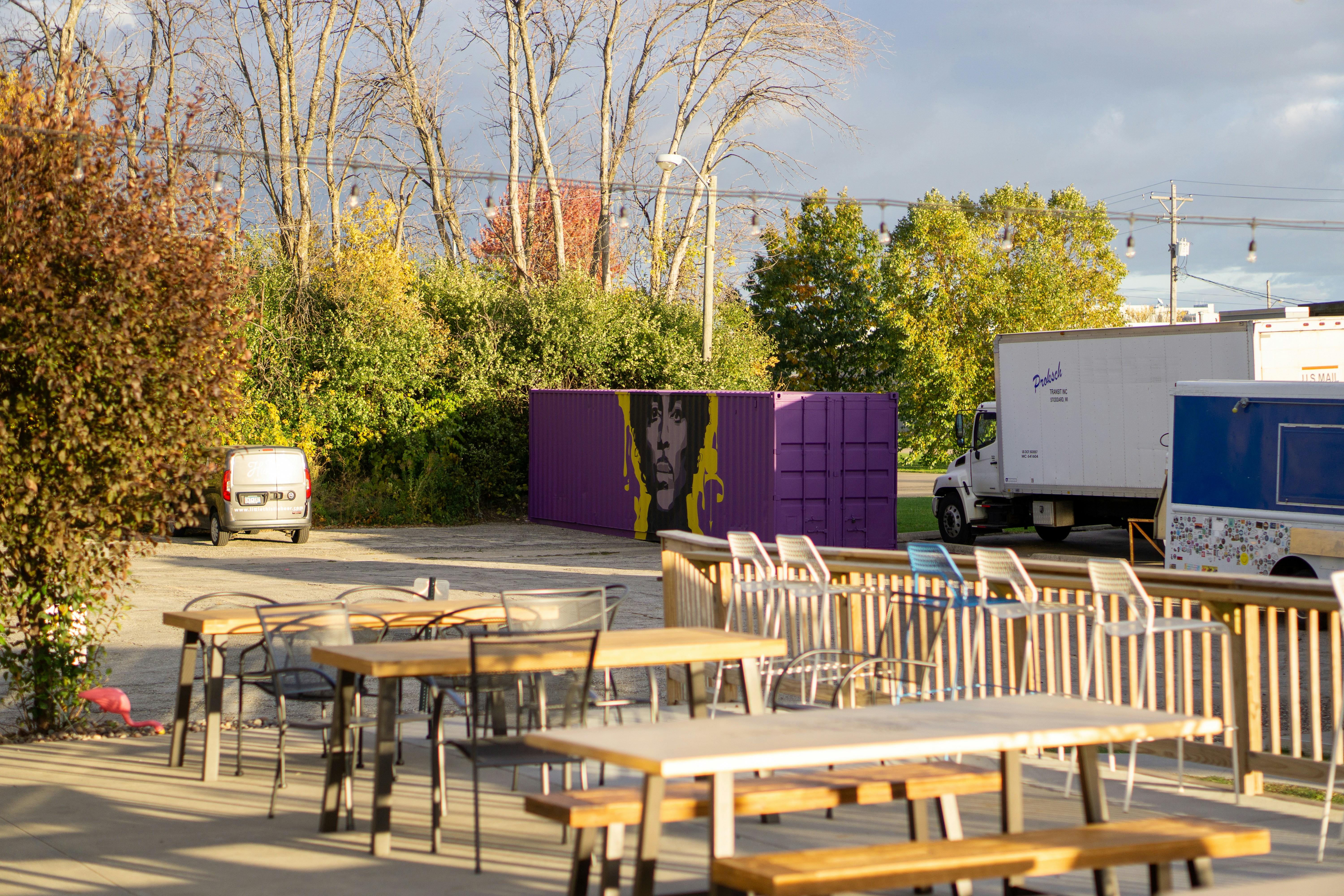 A group of tables and benches in a parking lot photo – Free Car Image ...