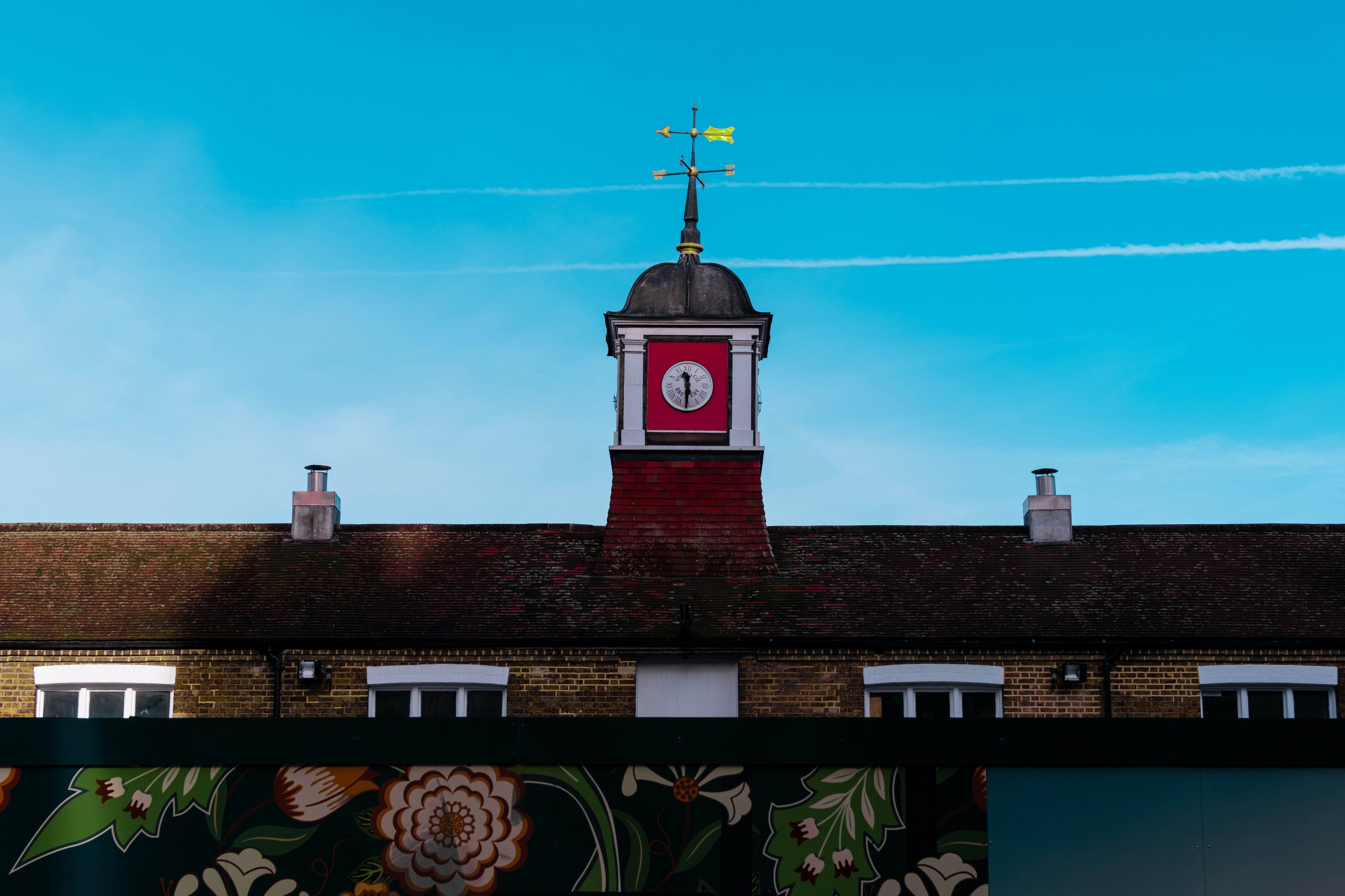 Clock Tower Crest: A Quiet Urgency Above the Floral Frieze