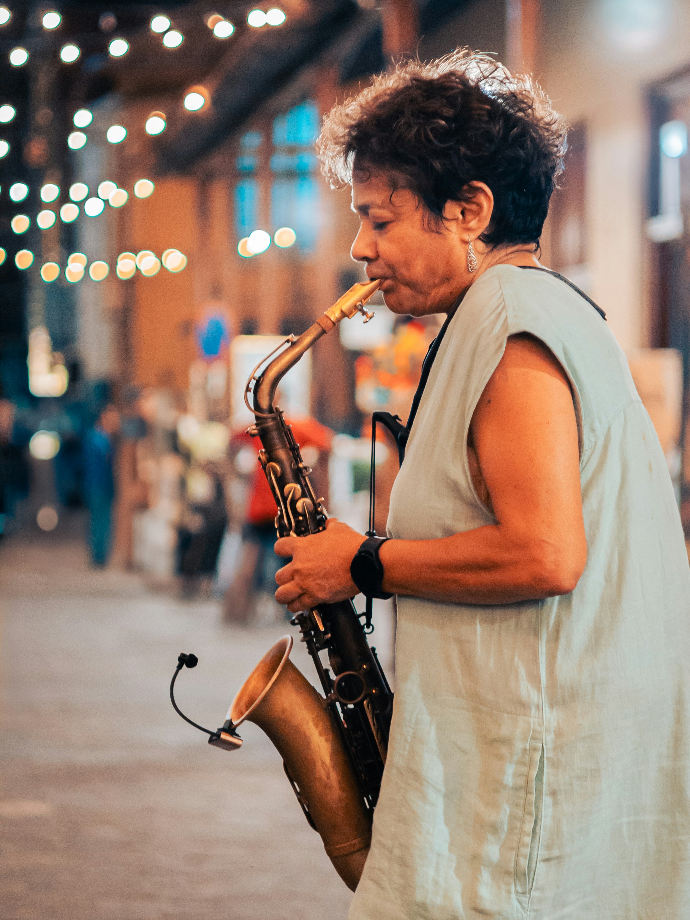 A woman playing a saxophone on a city street photo – Free Human Image ...