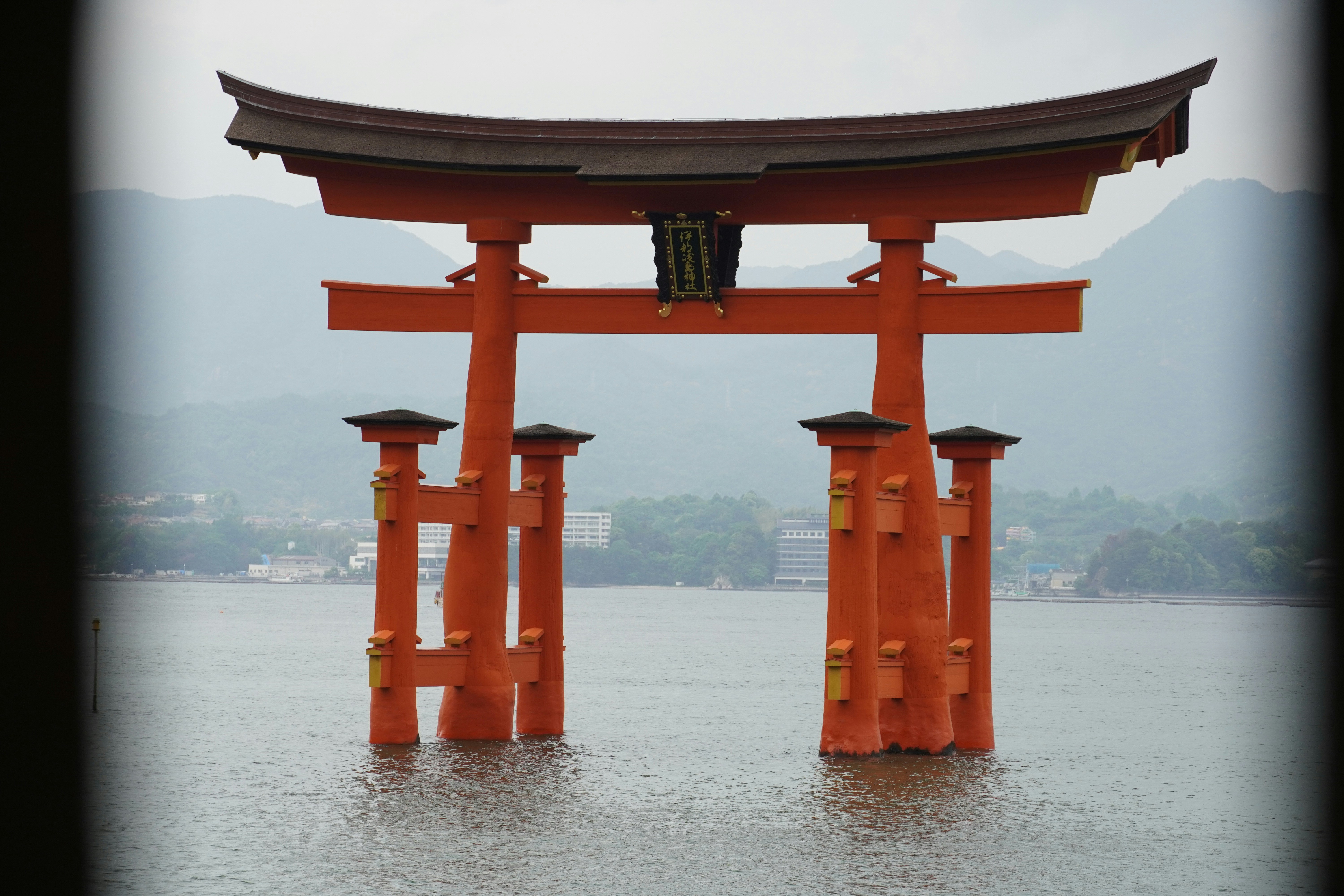 A large orange gate in the middle of a body of water photo – Free ...