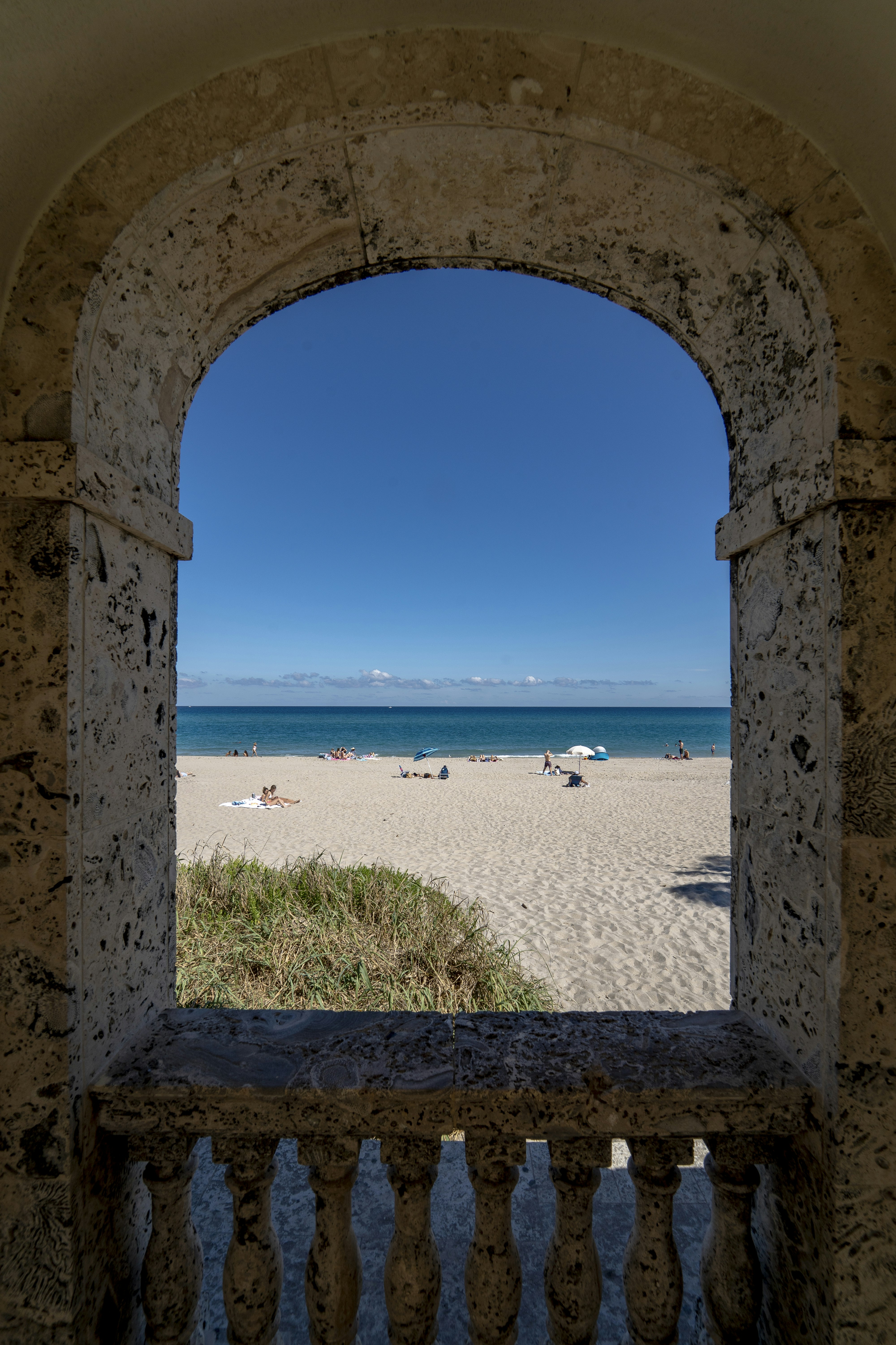 Archway to Blue Horizons: Beach Scene Framed in Weathered Stone