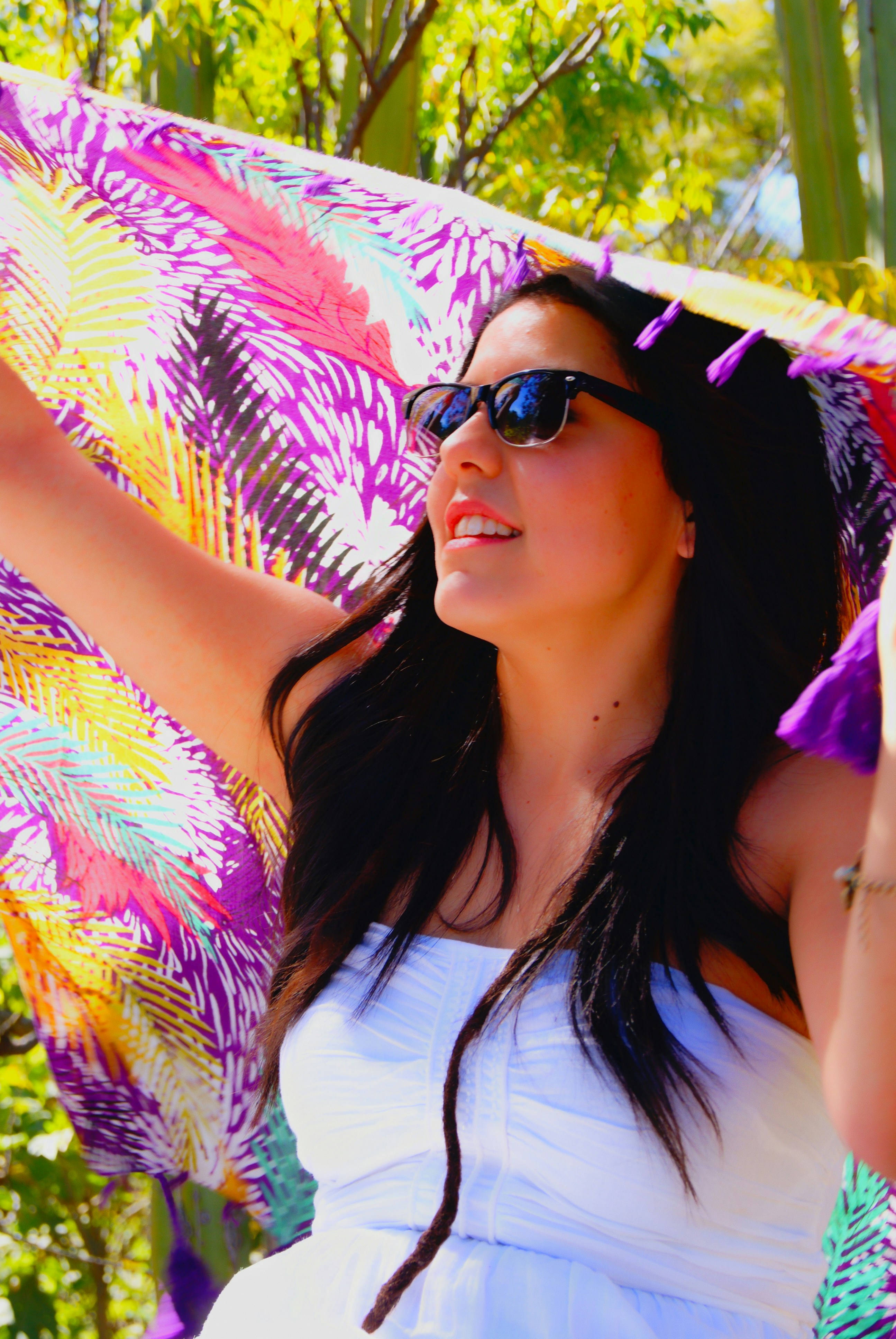 La mujer lleva gafas de sol y sostiene un chal de colores. foto ...