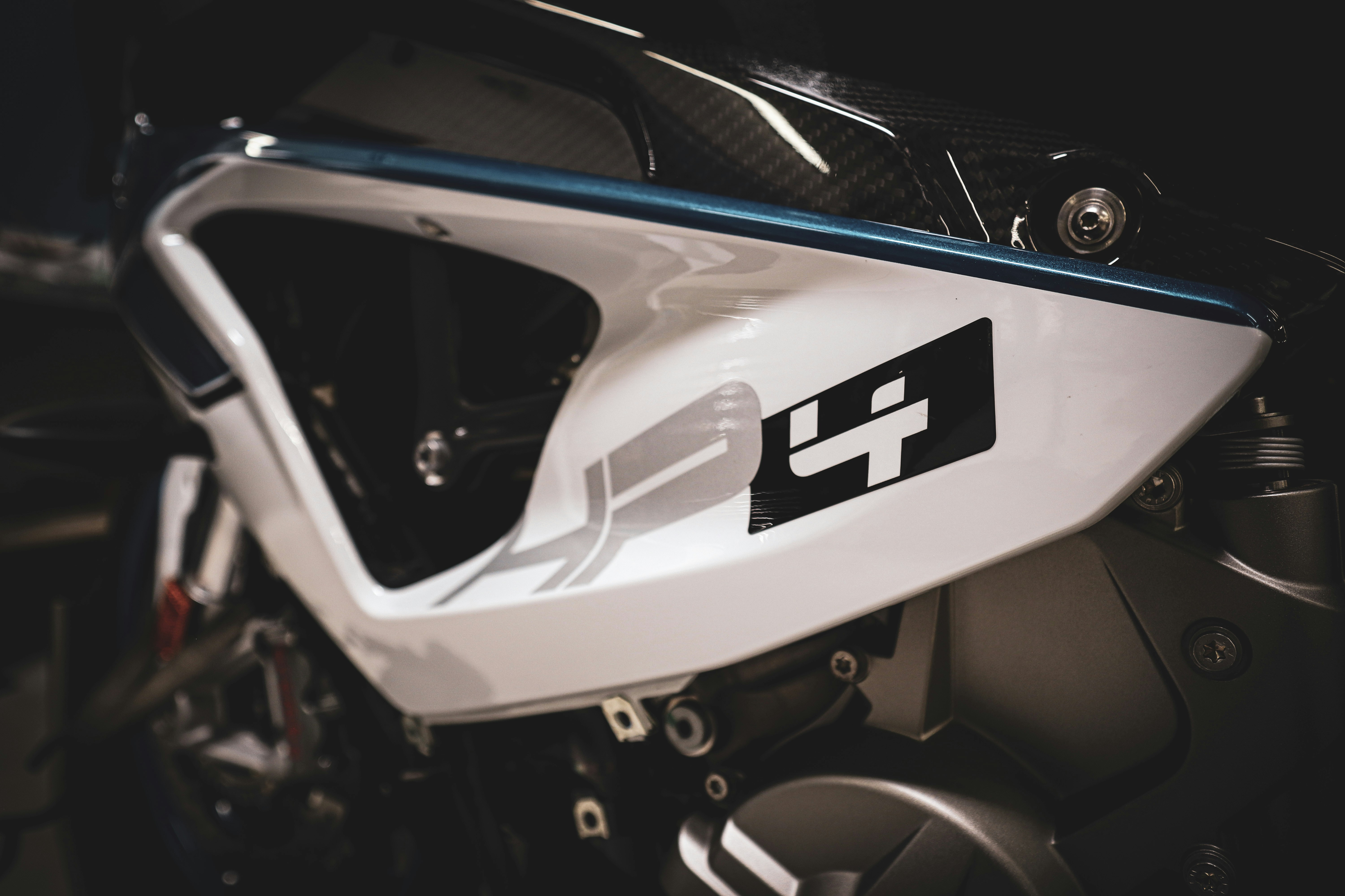 A white motorcycle with number "4" is shown. photo – Free Car Image on ...