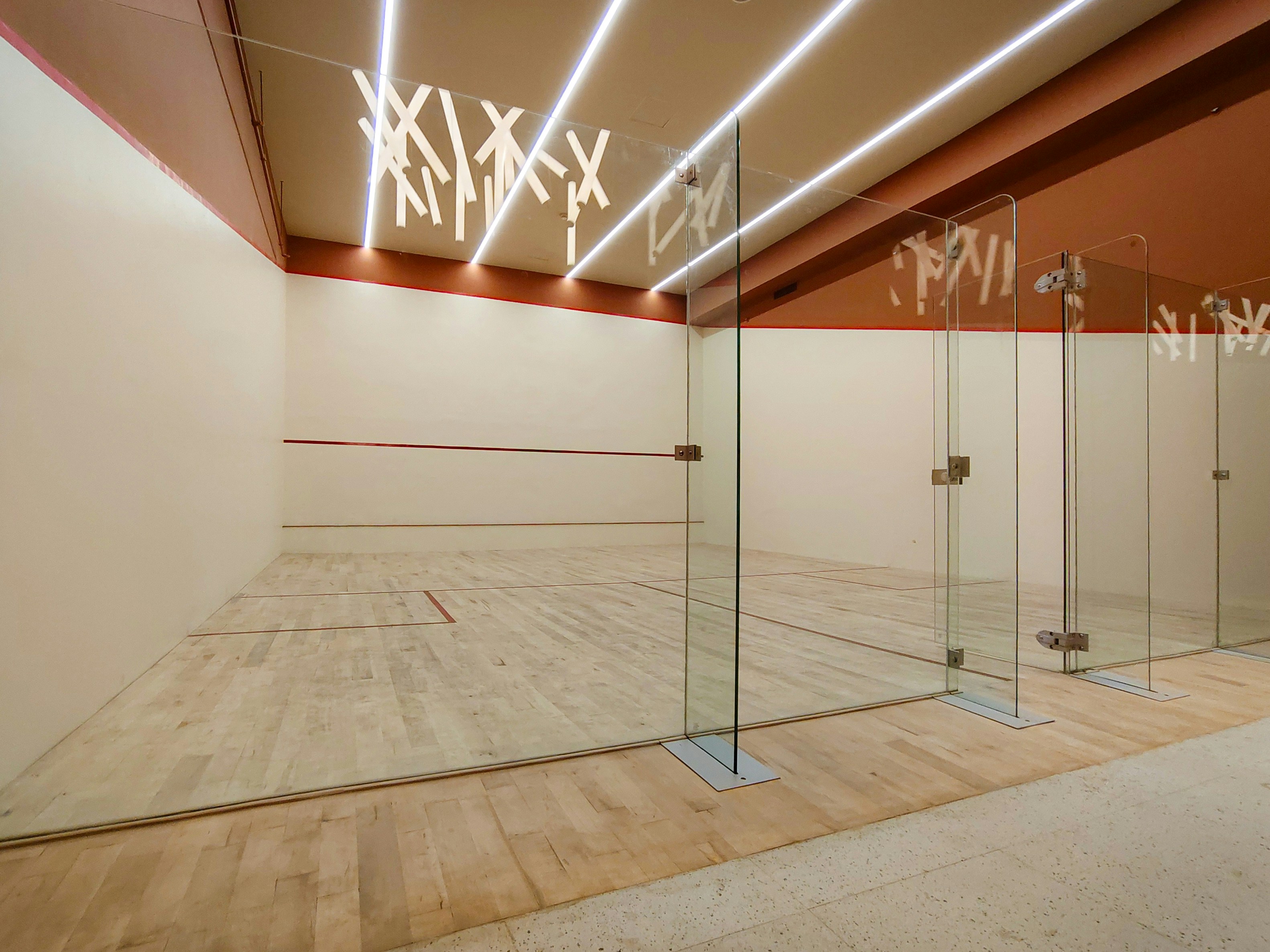 Voici une légende : un court de squash vide avec des murs en verre ...