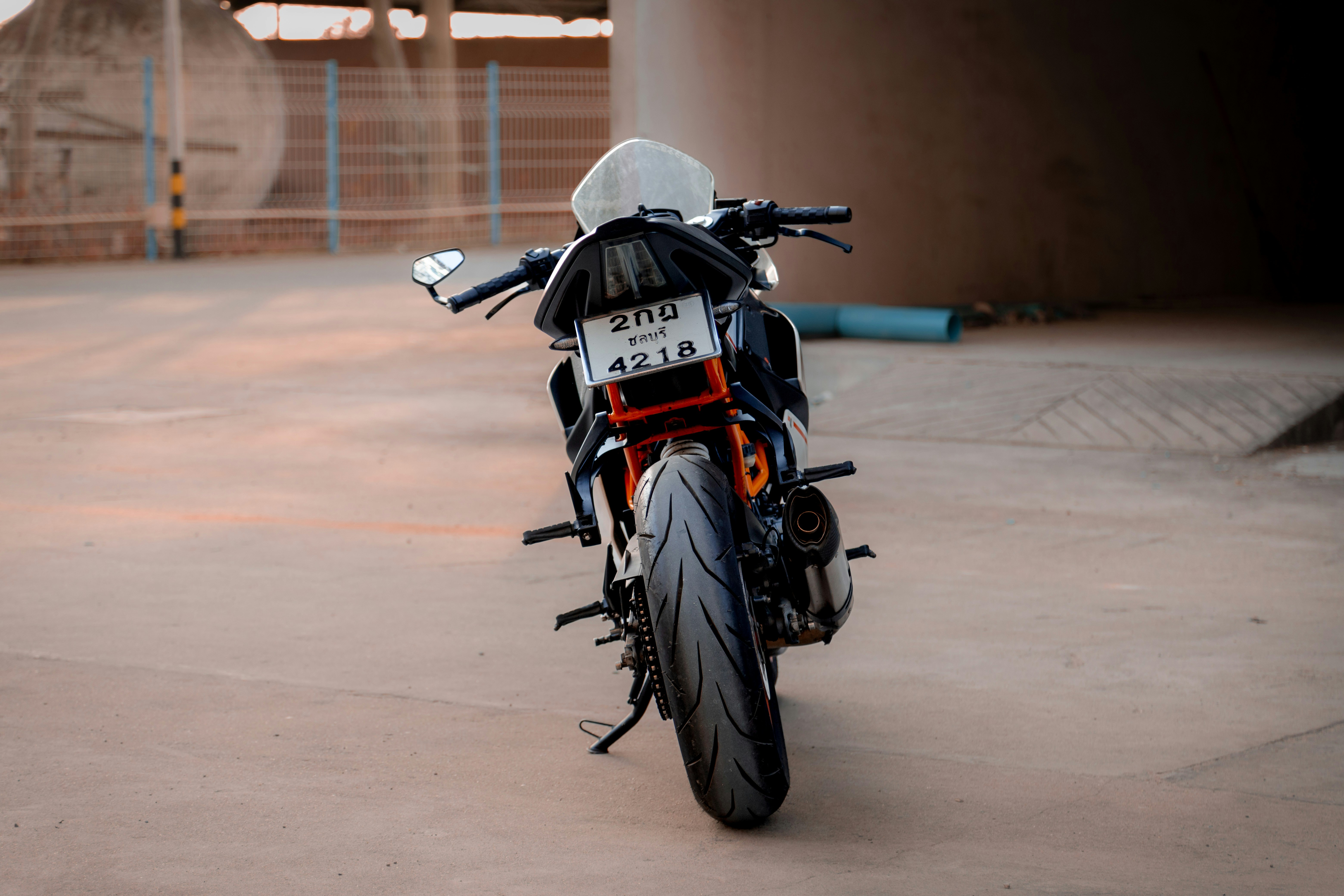 A motorcycle stands alone with its rear end facing the viewer. photo ...