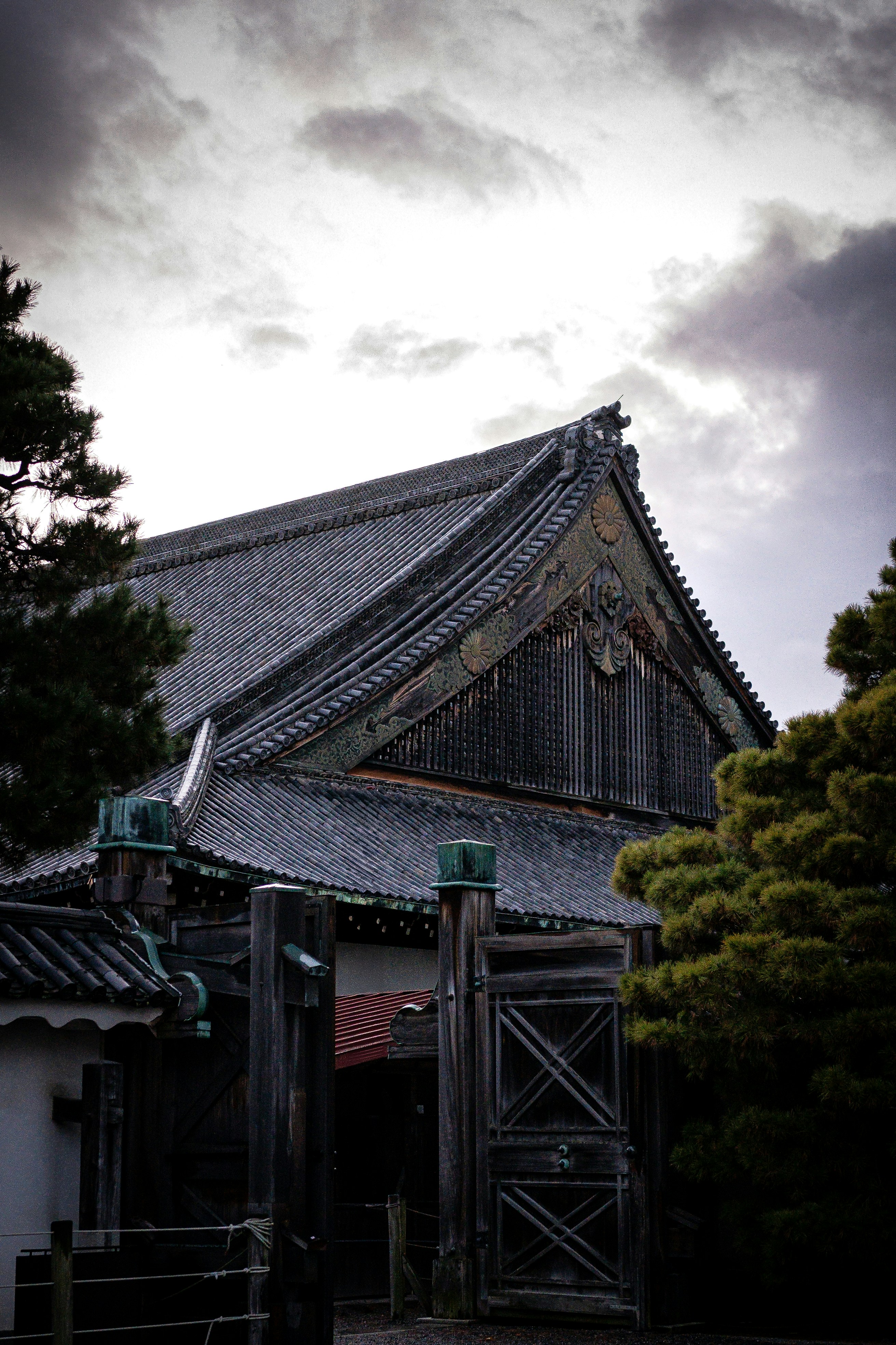 Temple Gable Above Carved Timber, Evening Mist over Old Gates