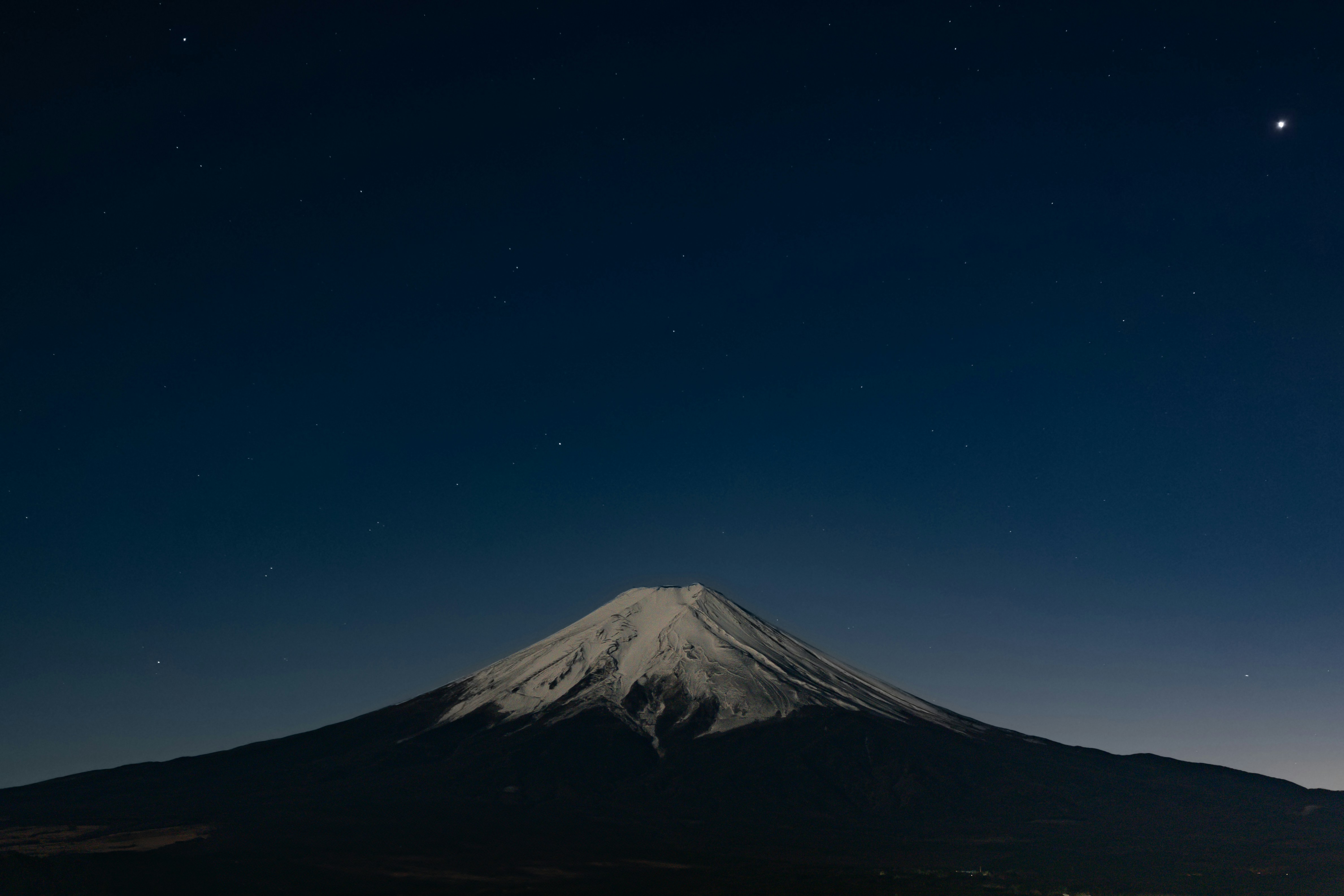 Snow-capped mount fuji stands under a starry night sky. photo – Free ...