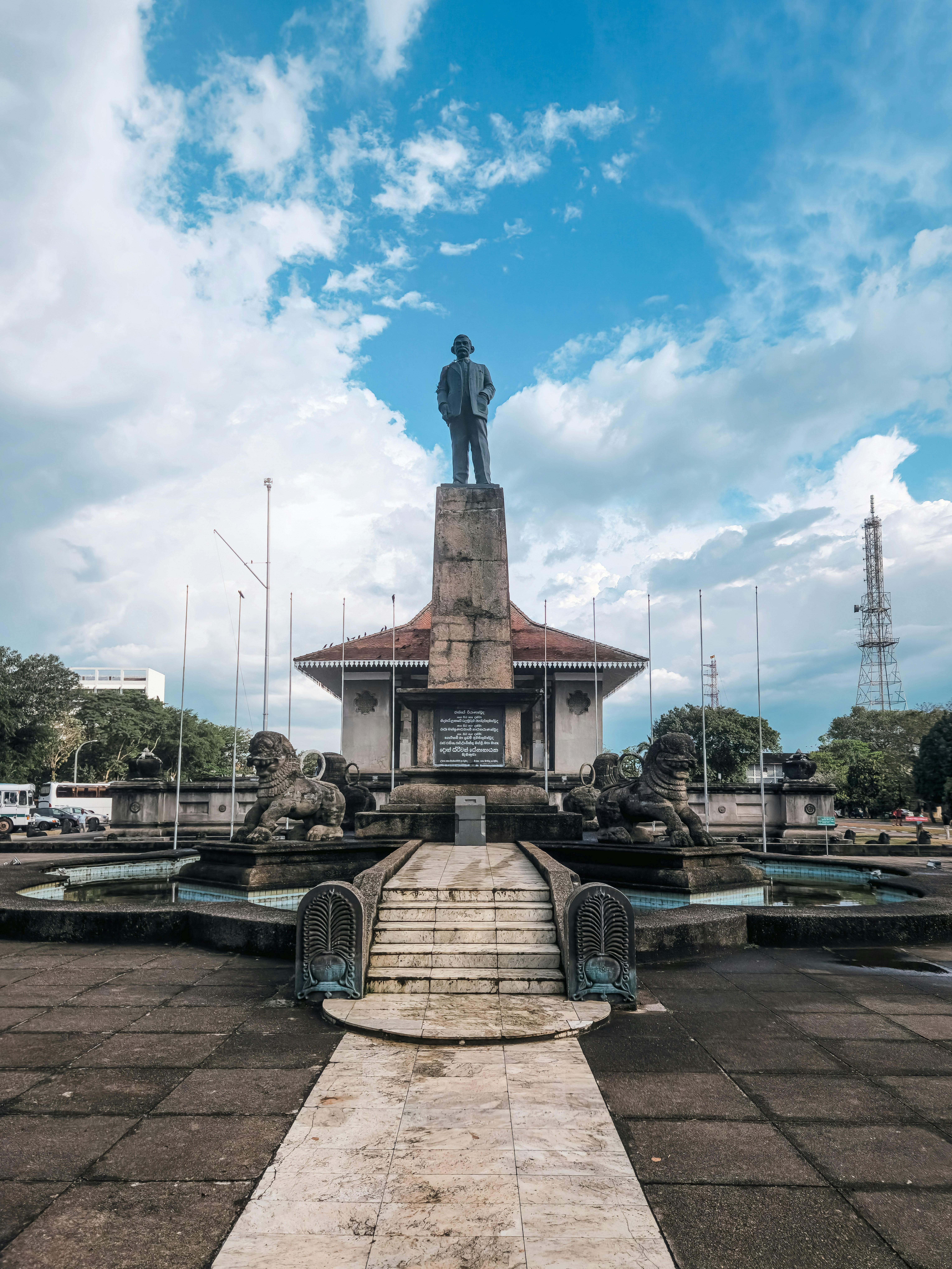 The Sentinel Plaza: A statue rising over a circular fountain beneath a broad blue sky