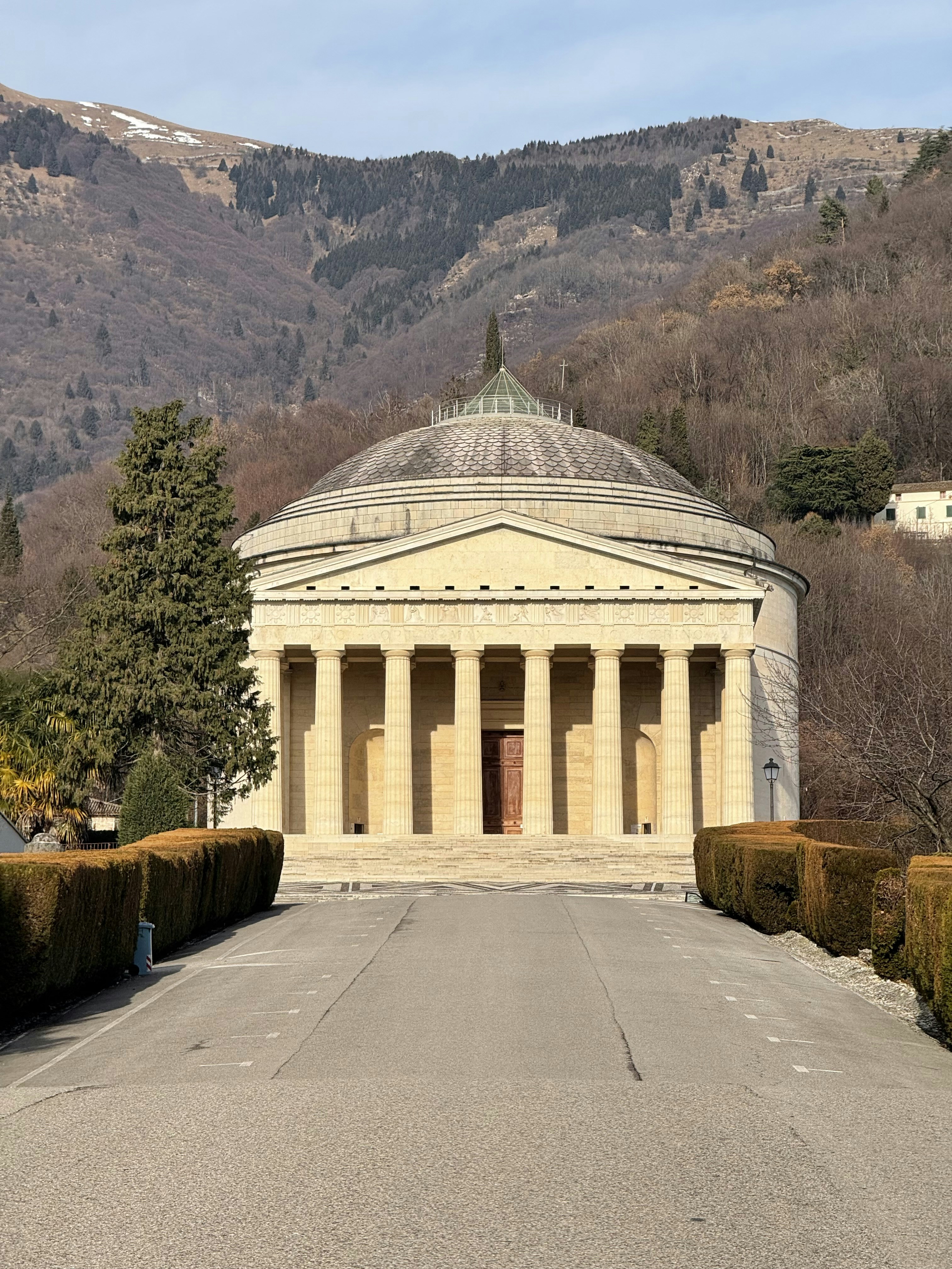 Historic circular building with classical architecture located in a mountainous area during daytime