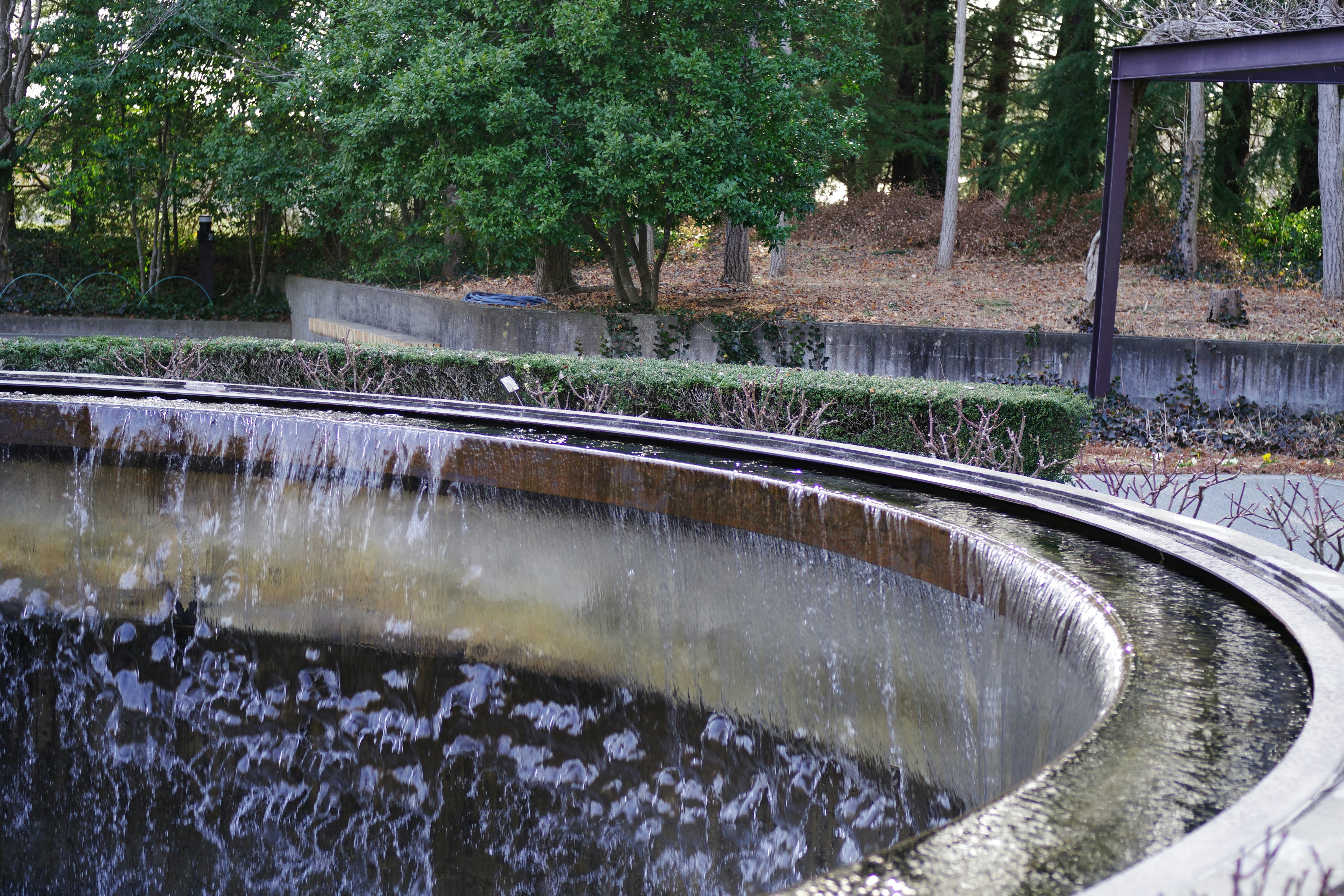 Water cascades over the edge of a circular fountain. photo – Free ...