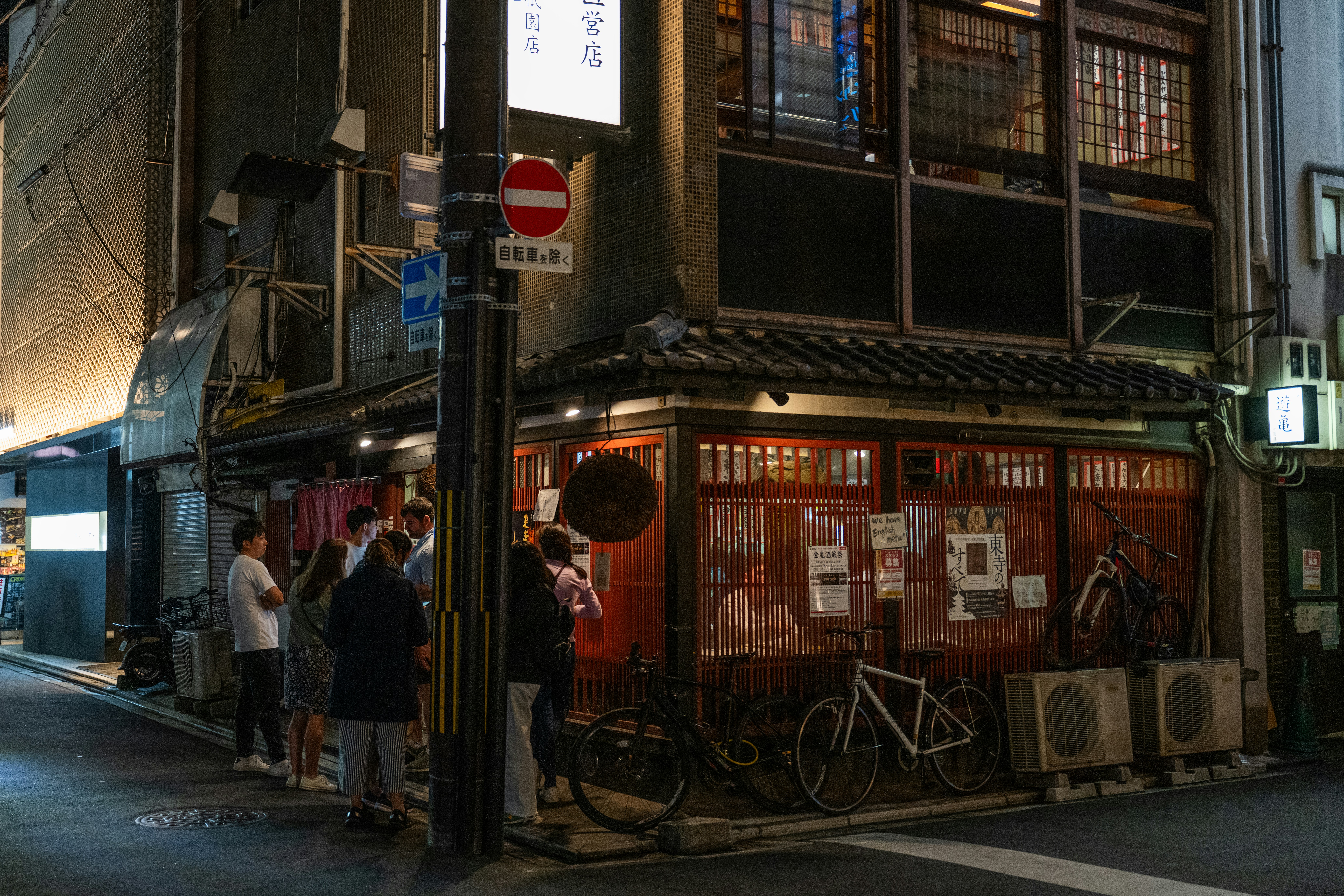 People standing outside a ramen noodle bar in Kyoto | People wait outside a japanese restaurant at night.