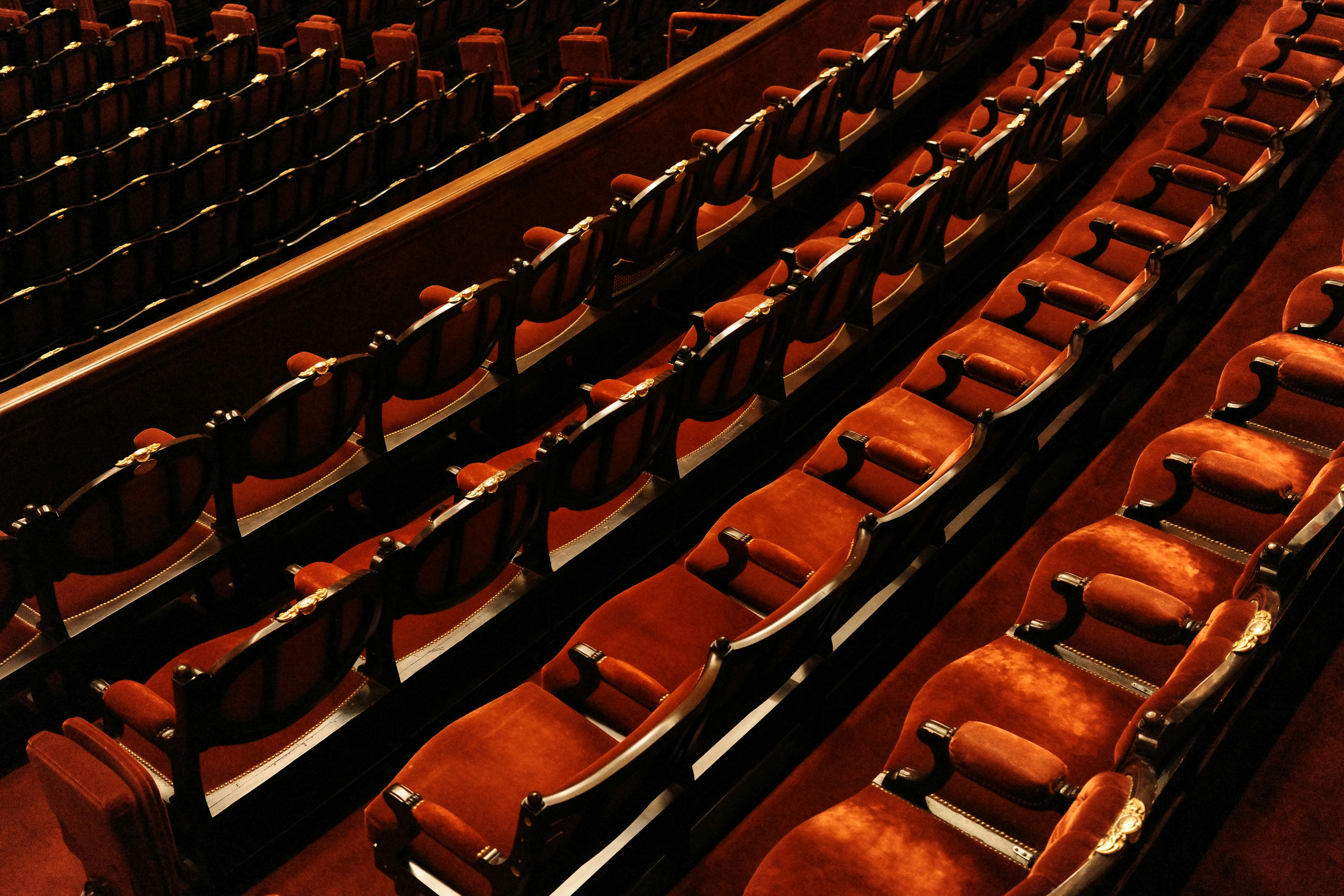 Rows of plush, red velvet theater seats arranged in elegant symmetry.