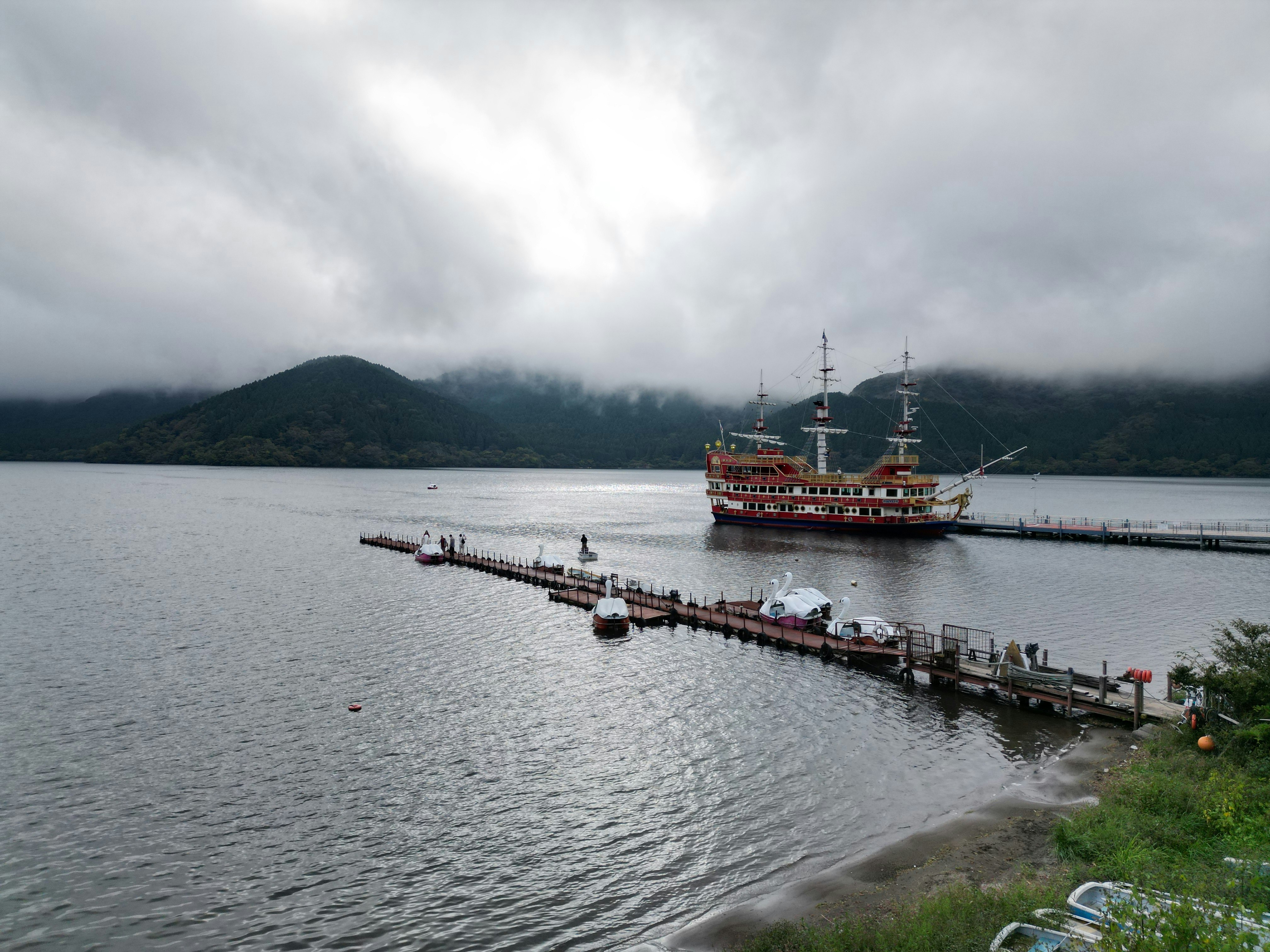 Traditional Japanese ship docked on Lake Hakone under a cloudy sky.