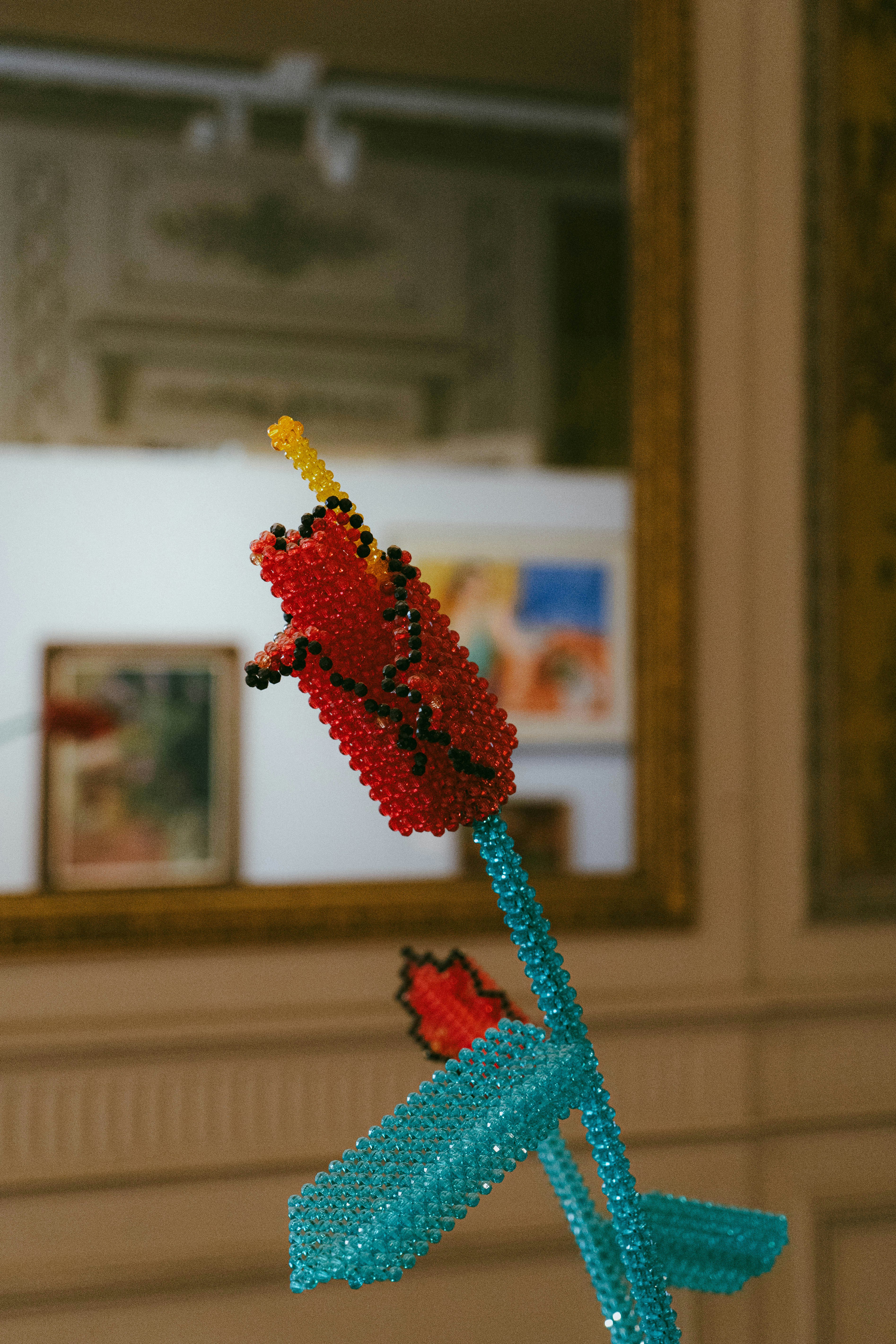 Beaded Dragon on a Turquoise Stem: A Tiny Sculpture in a Quiet Gallery Corner