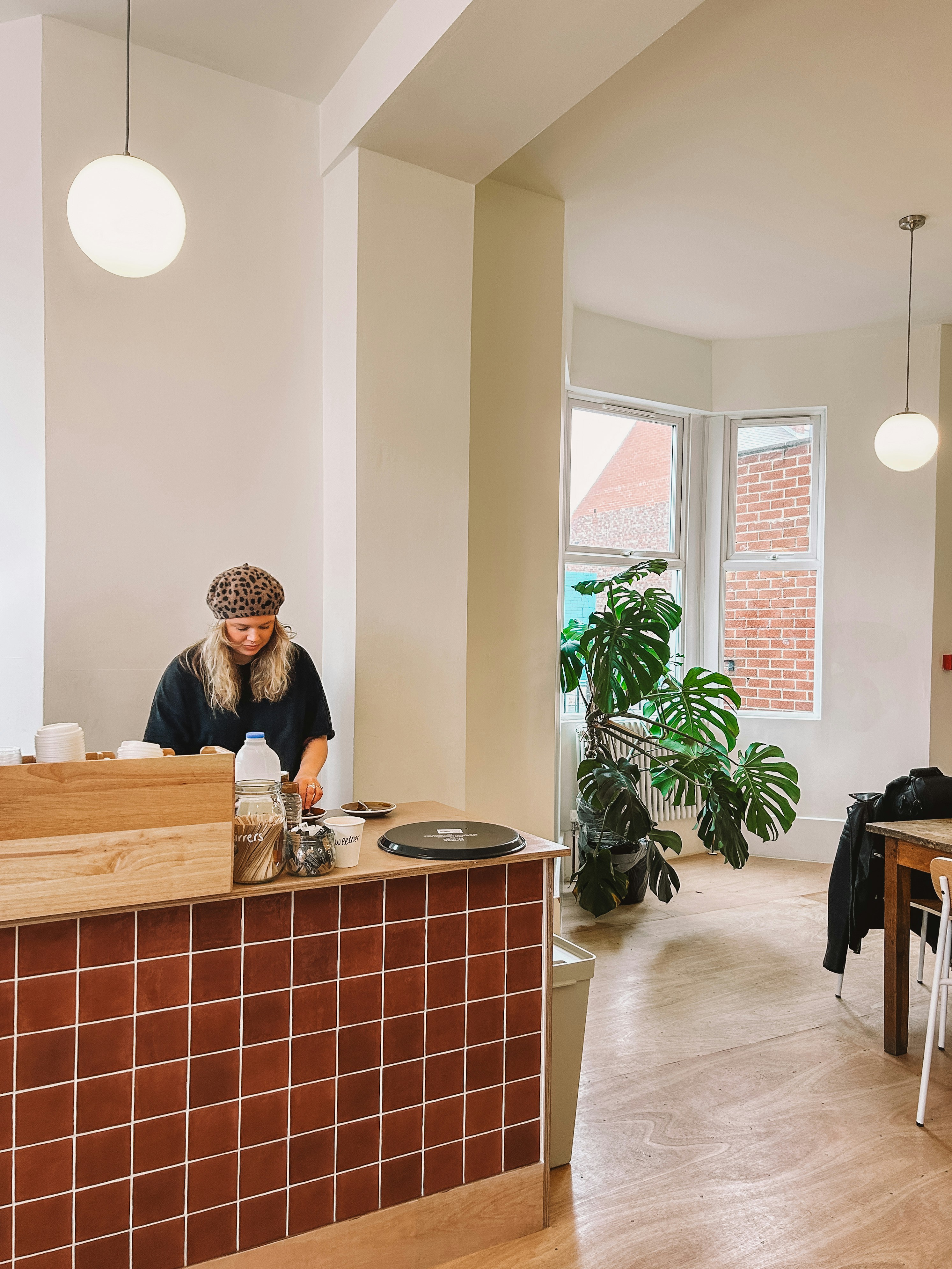 A person standing at a counter in a room photo – Free Woman Image on ...