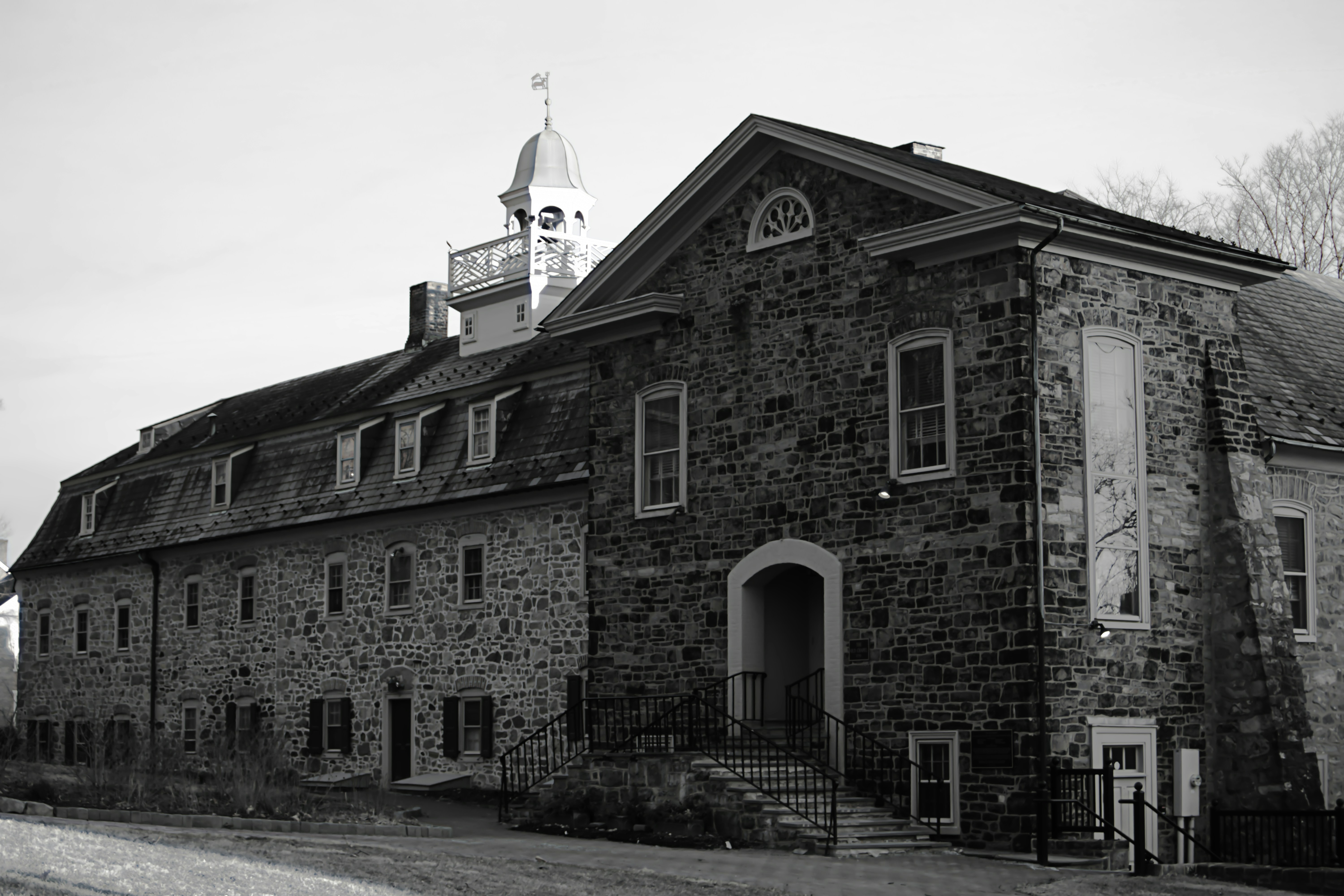 Historic stone building with a cupola and arched windows, enveloped in soft, overcast lighting.