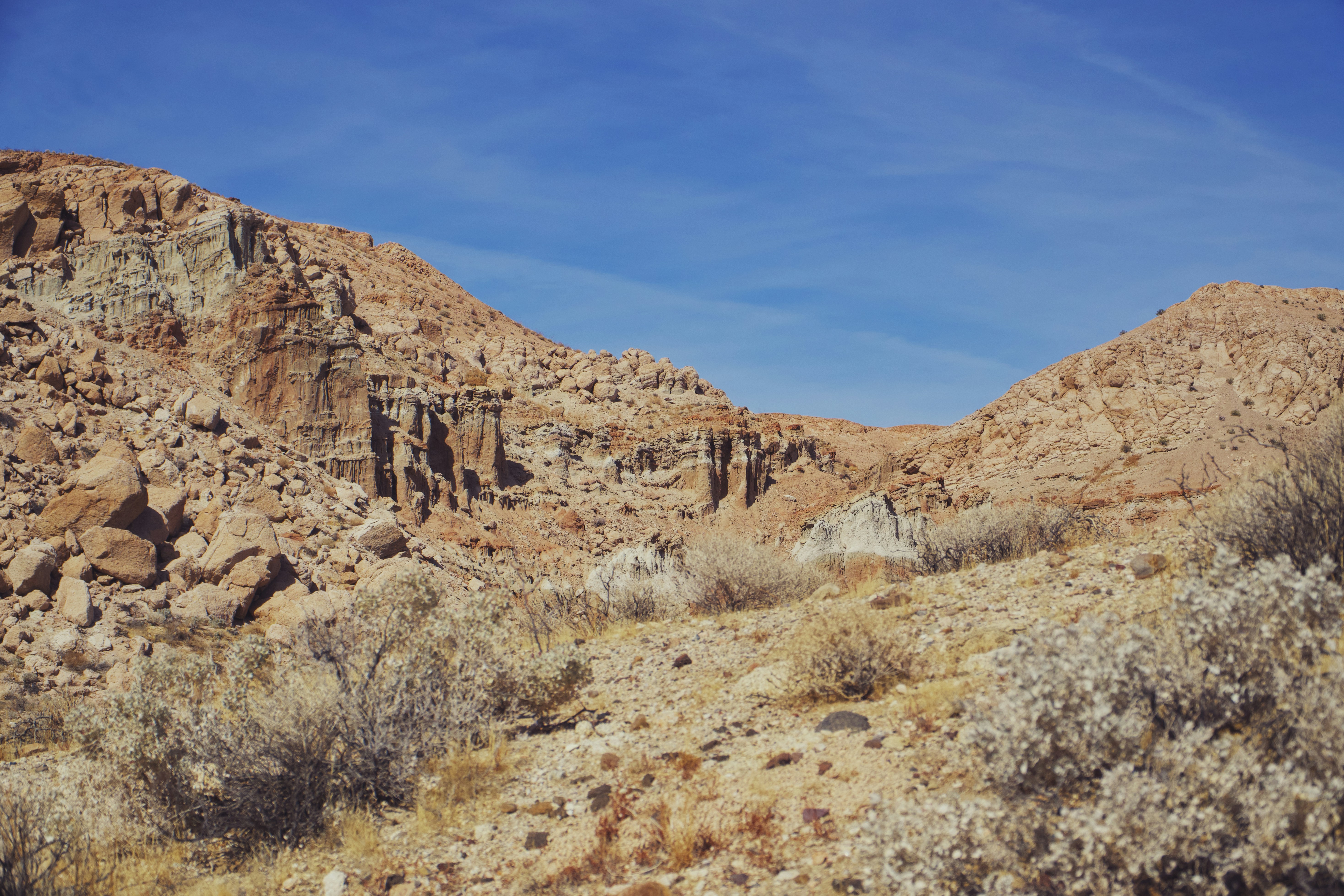 Desert landscape with rugged red rock formations under a clear blue sky.