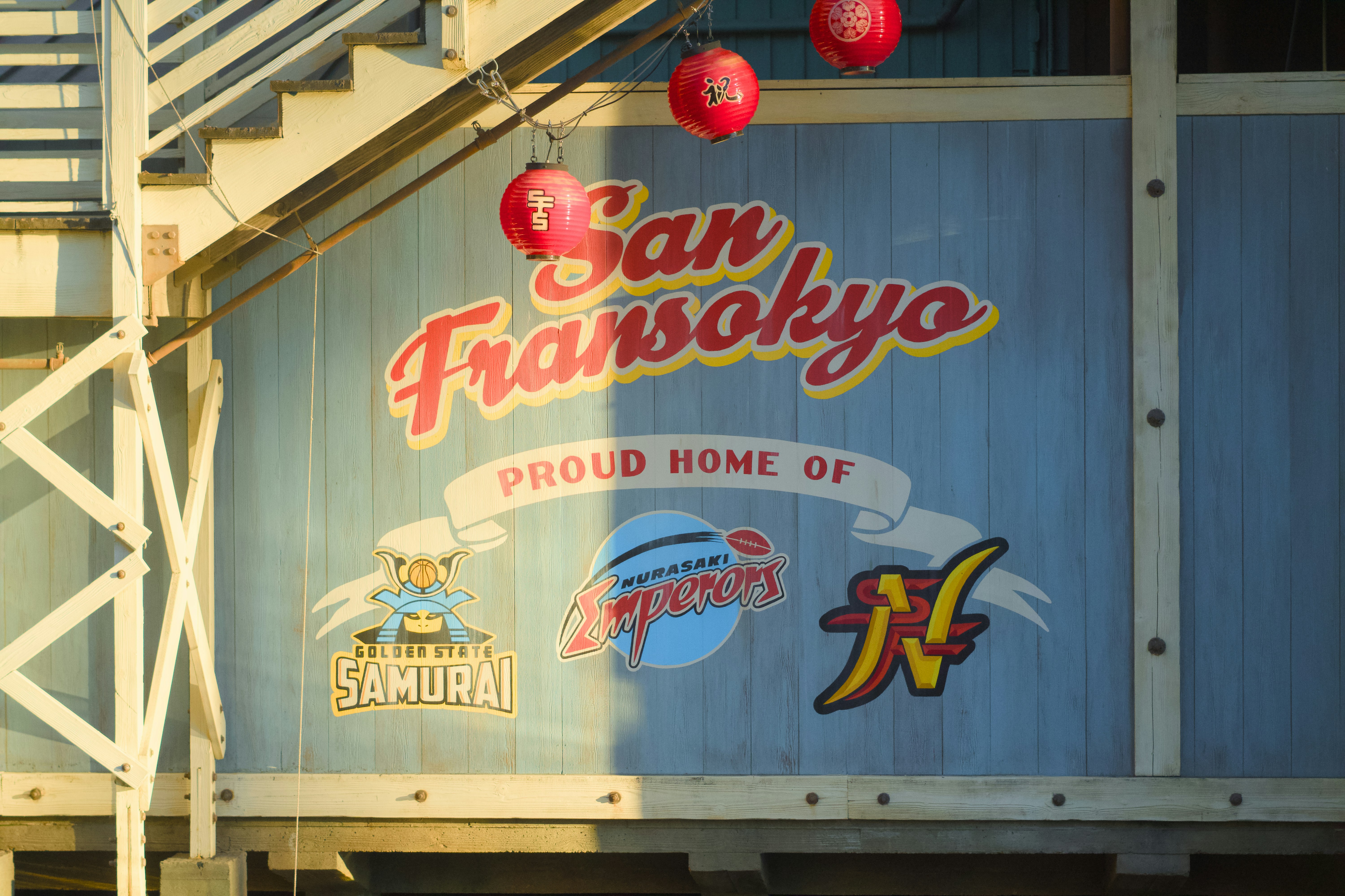 Colorful wall art featuring 'San Fransokyo' with logos of fictional teams under sunlight.