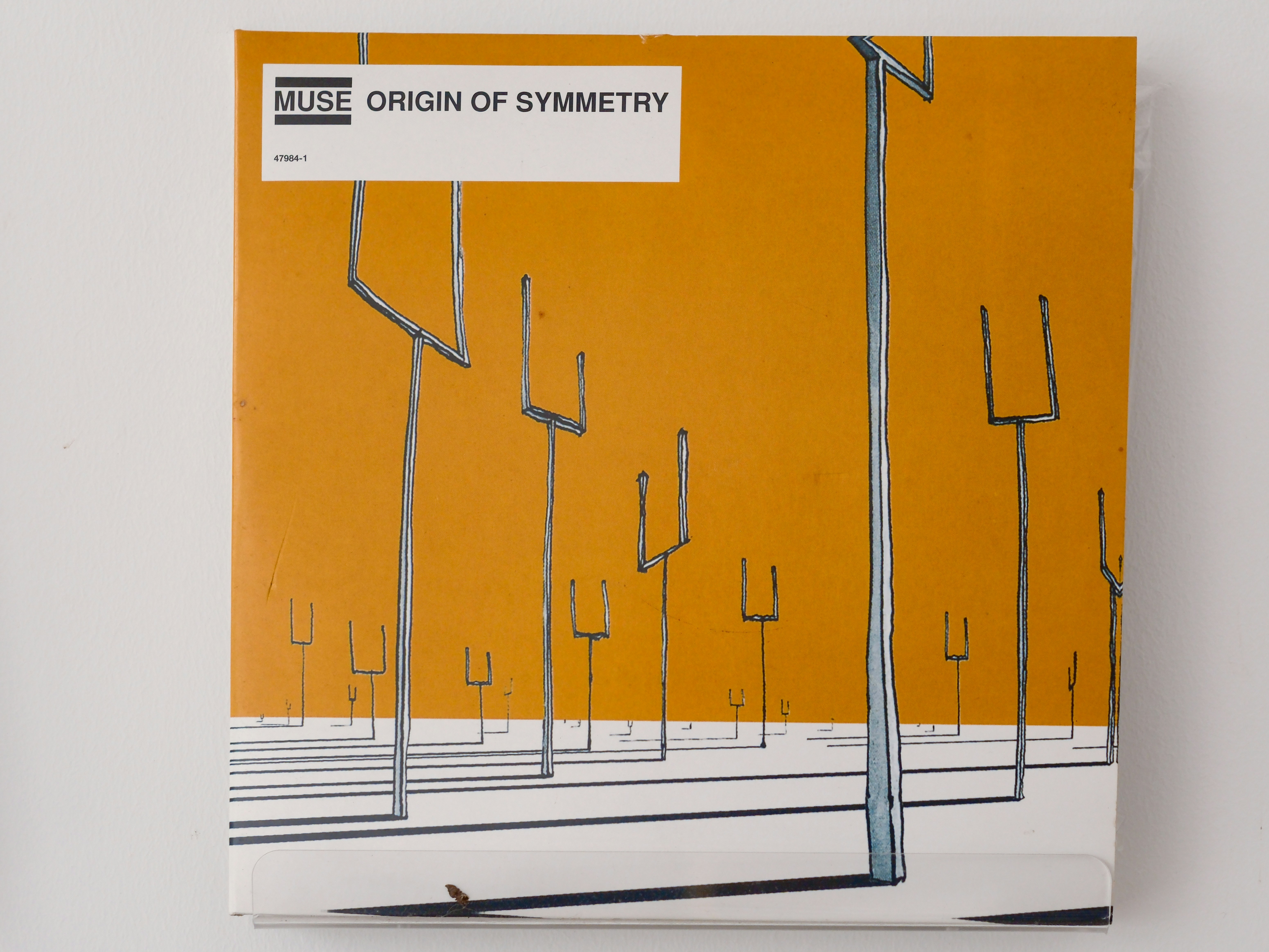 Album cover with abstract trees on a vibrant orange background.