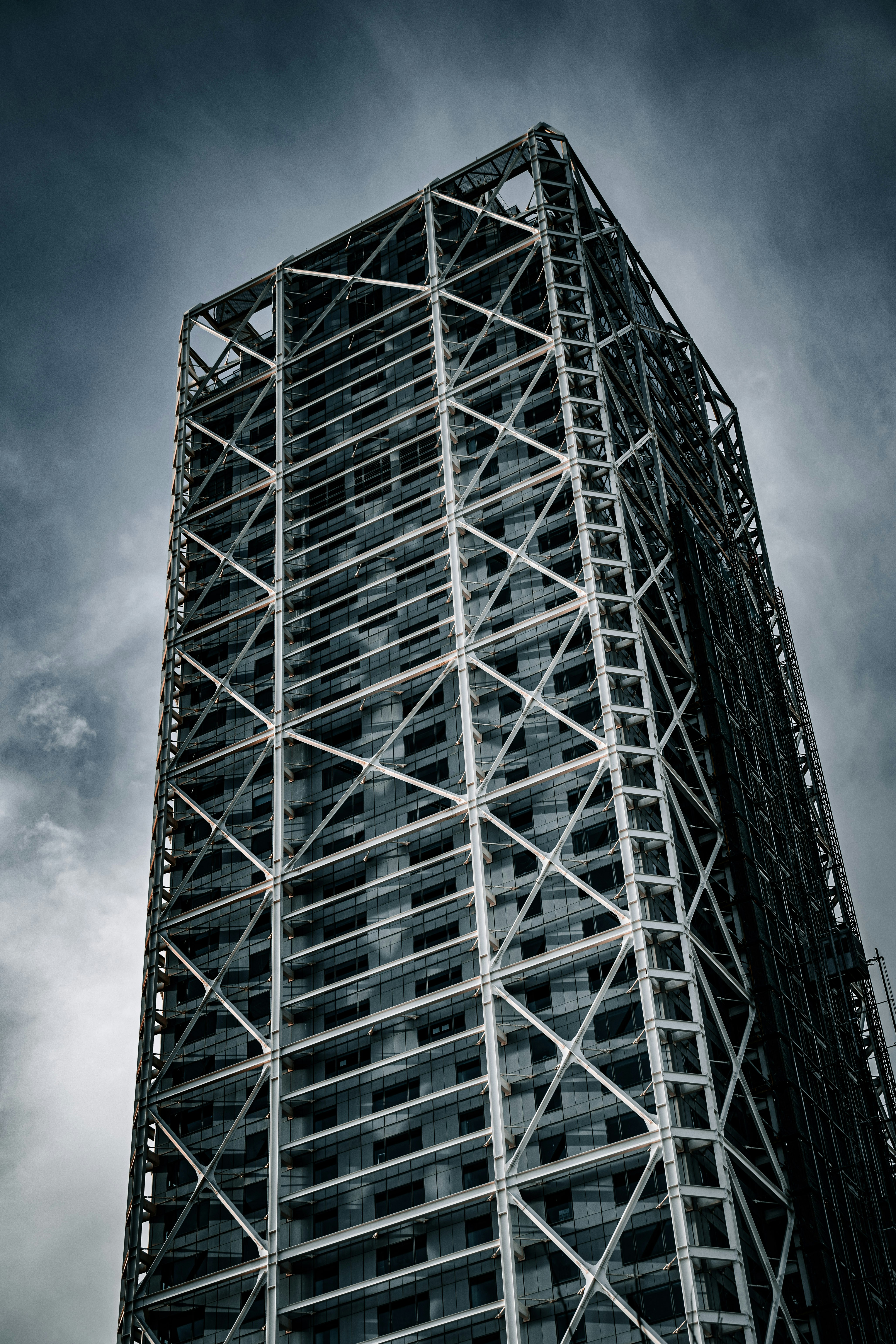 A modern residential skyscraper with a sleek metal structure, standing tall against the skyline, showcasing contemporary architectural design.