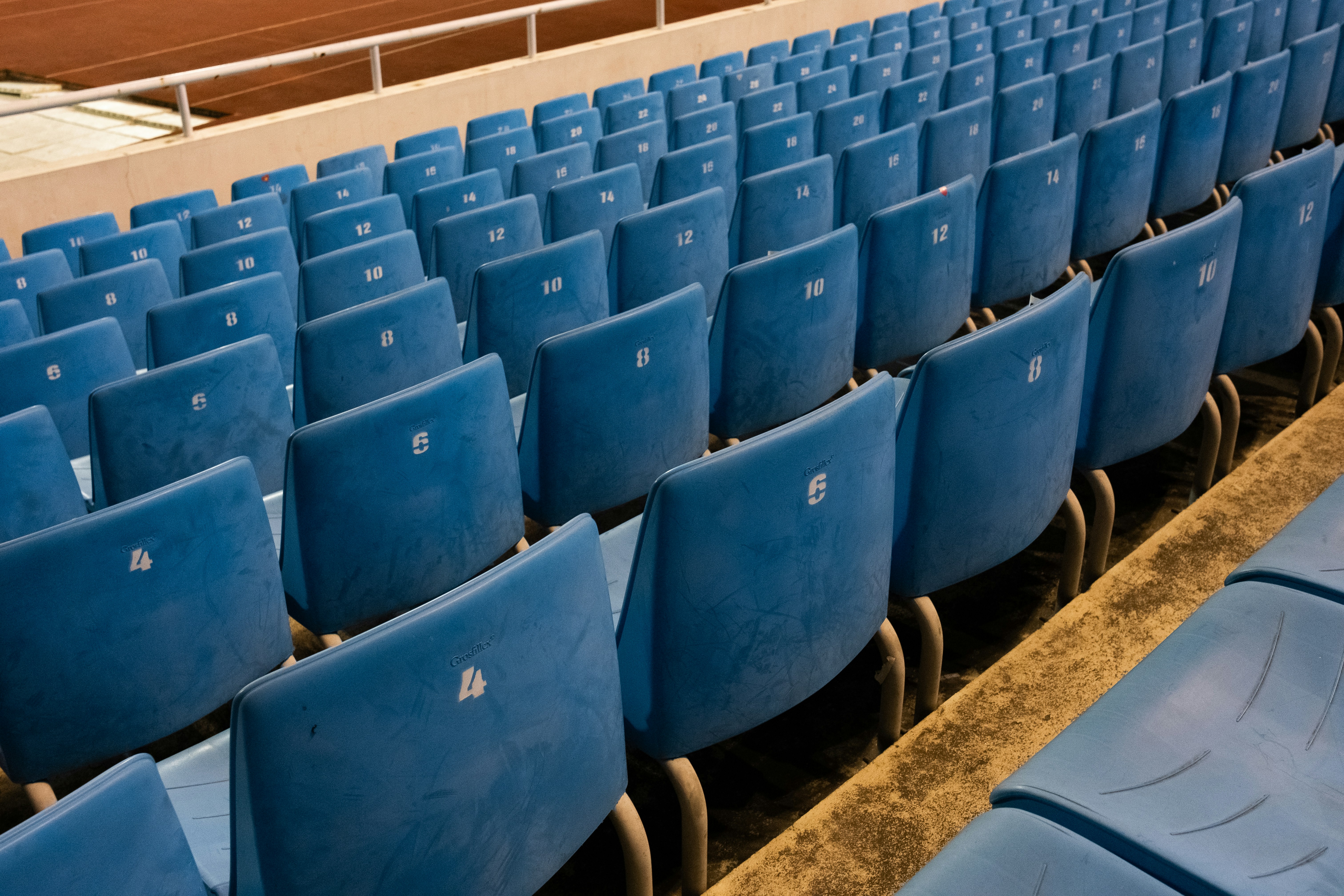 Rows of blue numbered stadium seats under soft lighting.