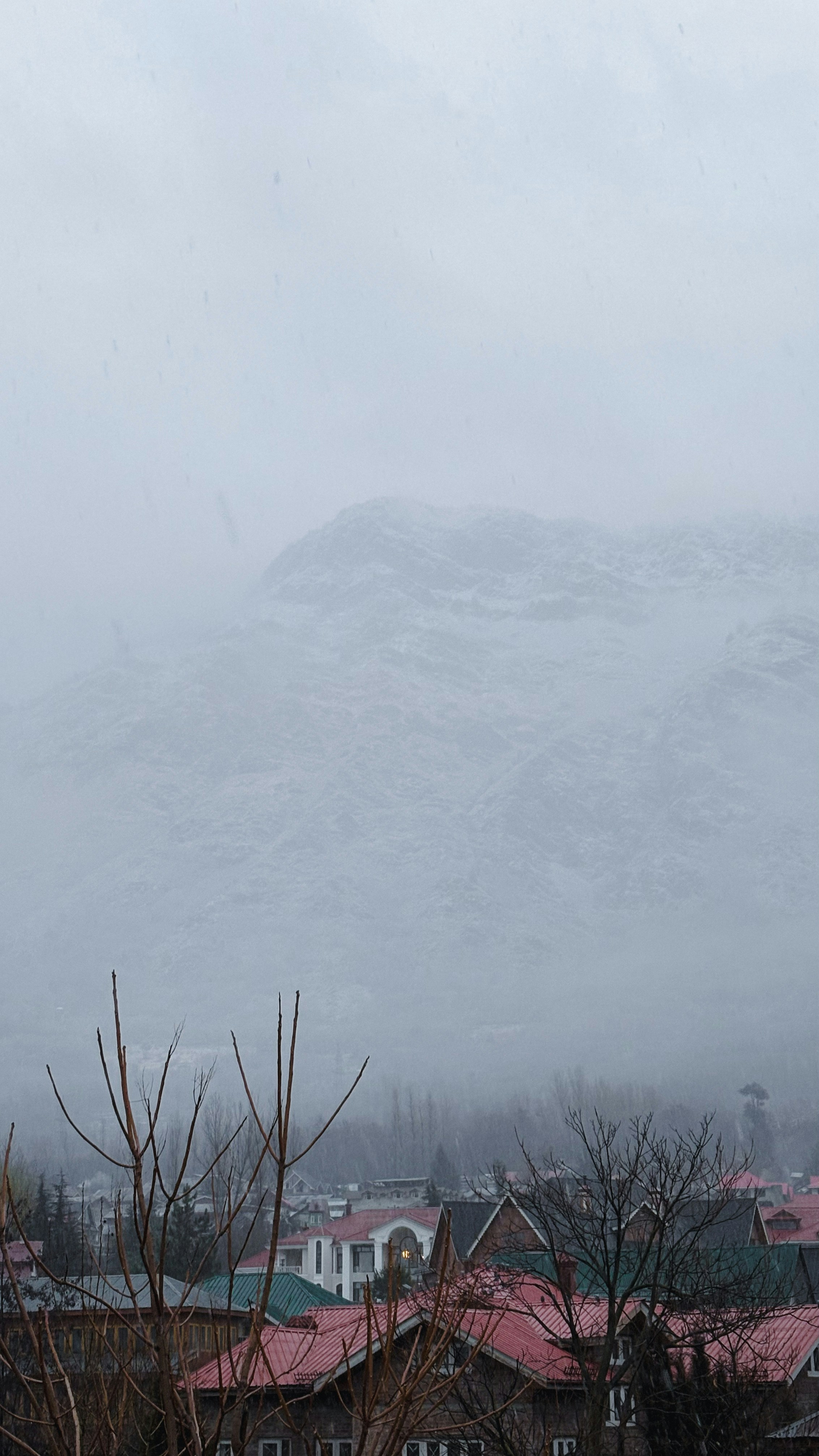Mist-Wedged Ridge Over a Valley of Red Roofs