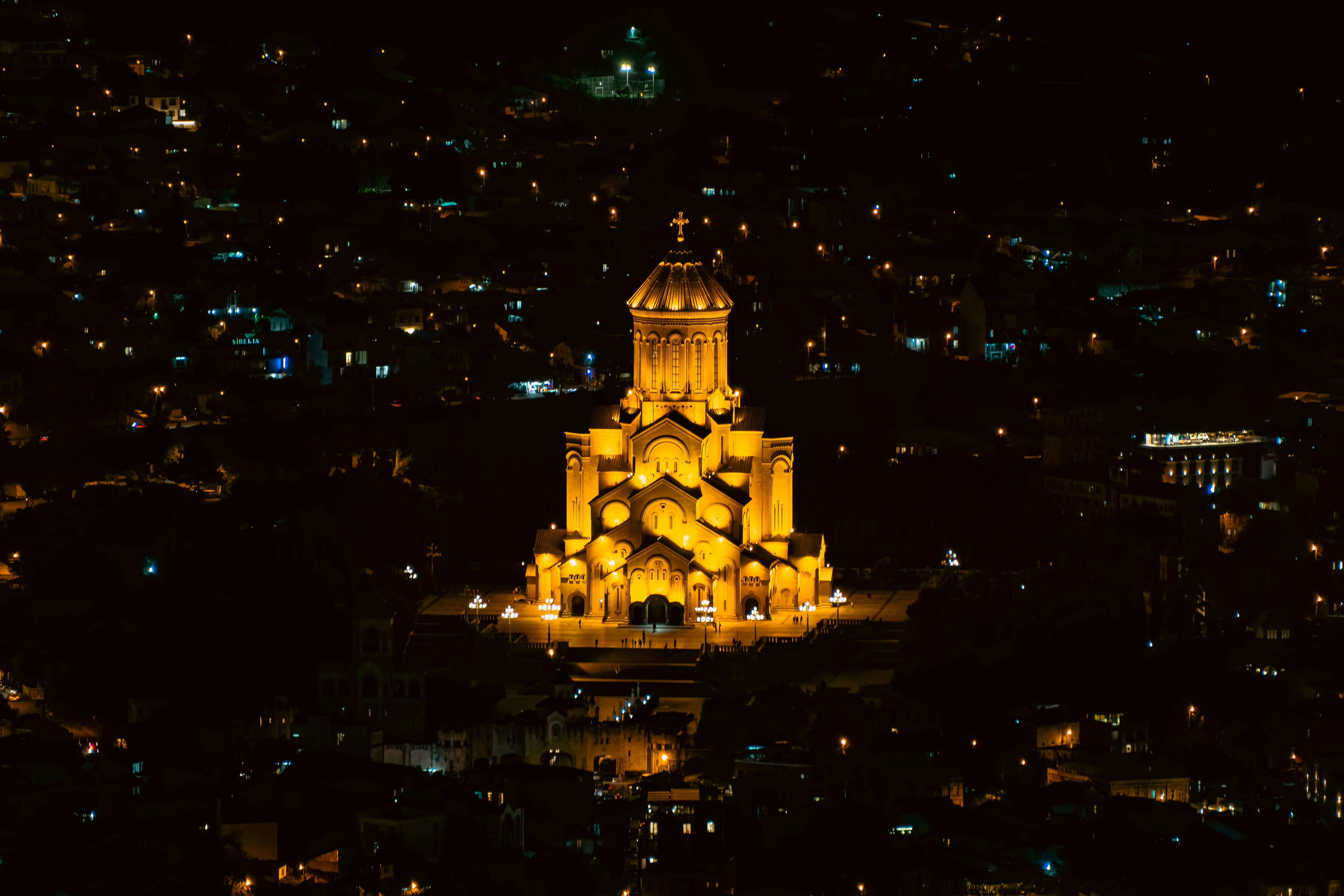 Tbilisi Holy Trinity Cathedral | A night view of a city with a clock tower
