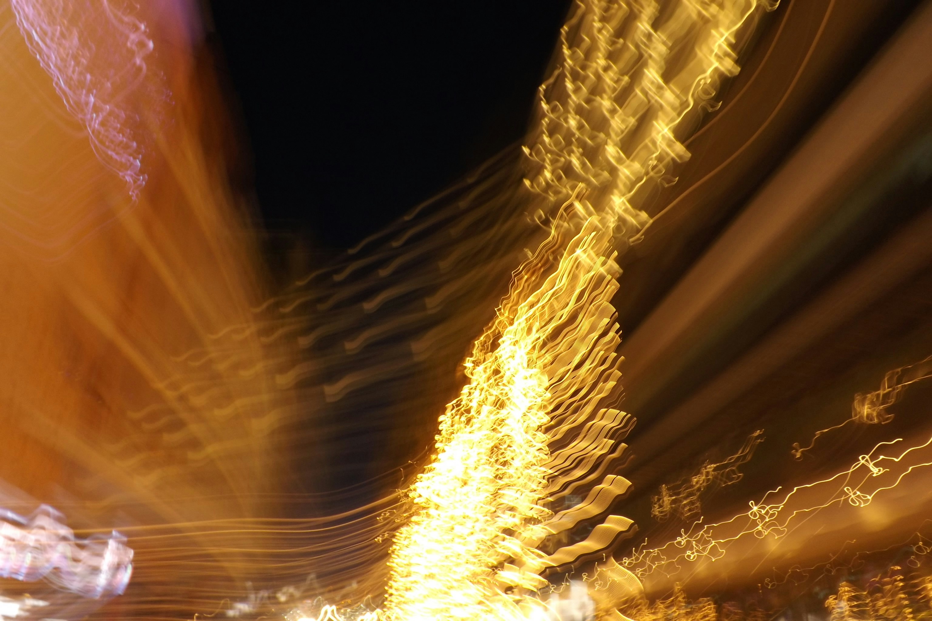 Streaks of golden lights curve across a dark urban backdrop, creating a dynamic sense of motion.